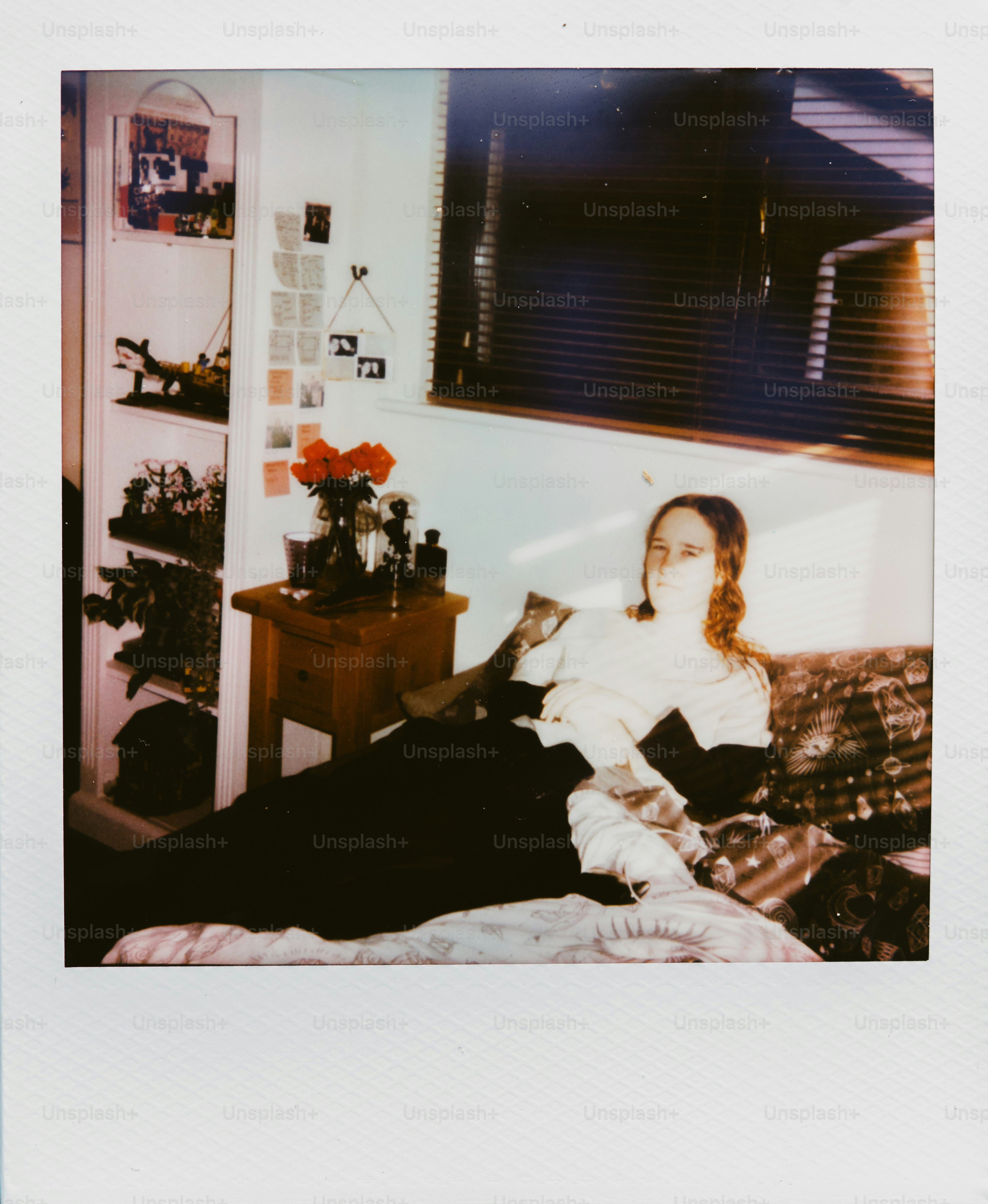Woman relaxing on a bed in a bedroom. photo – Polaroid Image on Unsplash