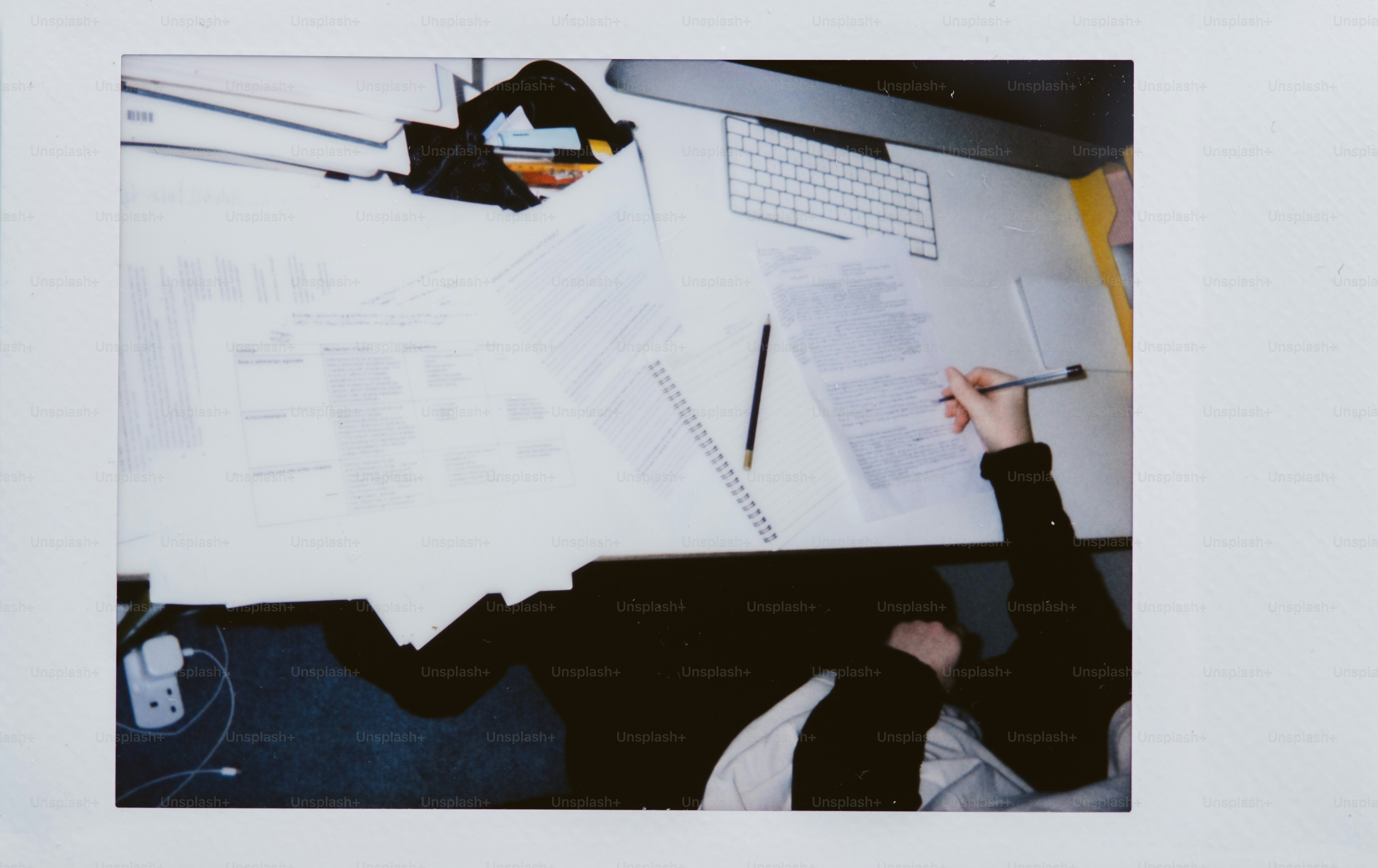 Person writing at a desk with papers and keyboard. photo – Education ...