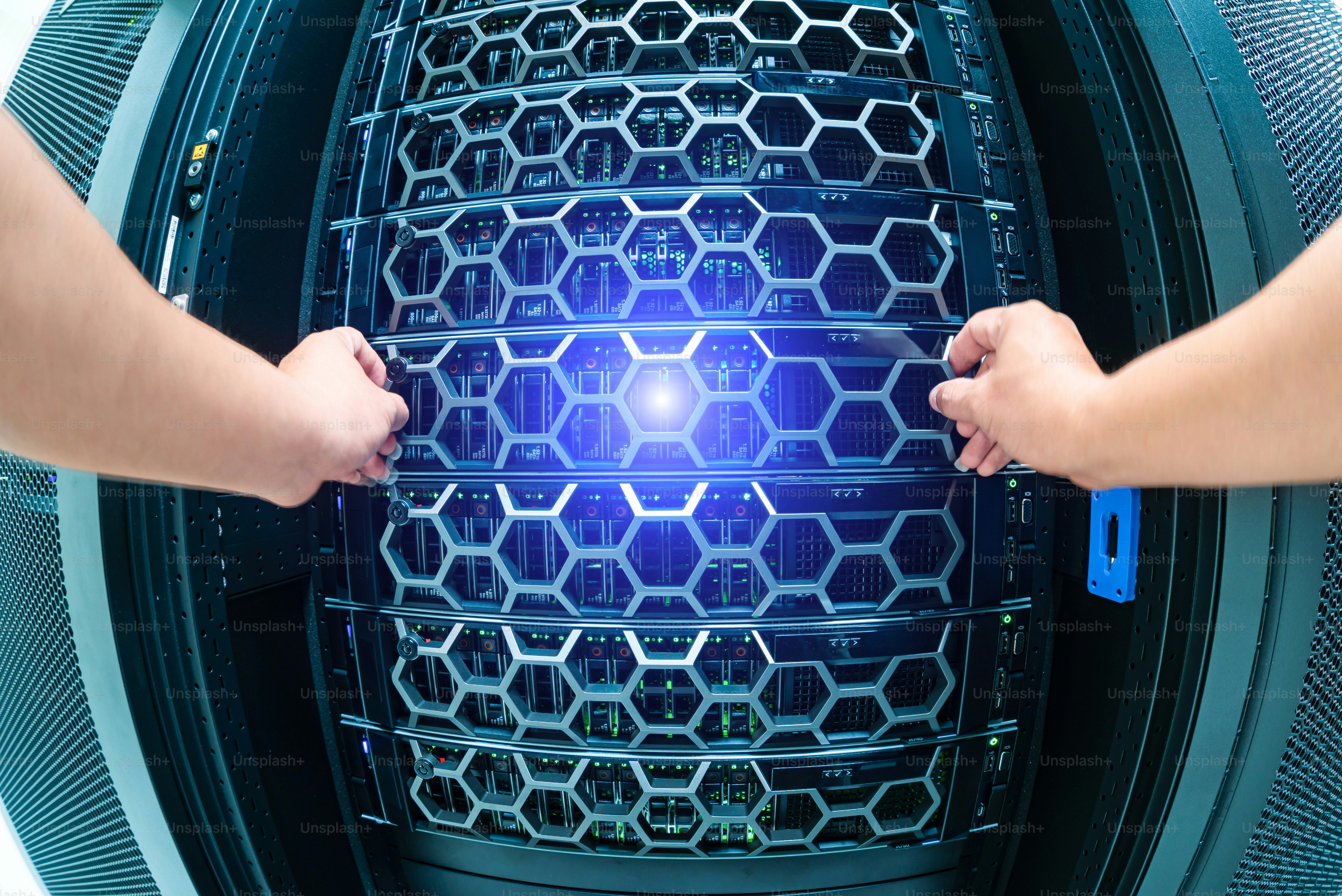 A technician is seen removing a server component from a stack in a ...