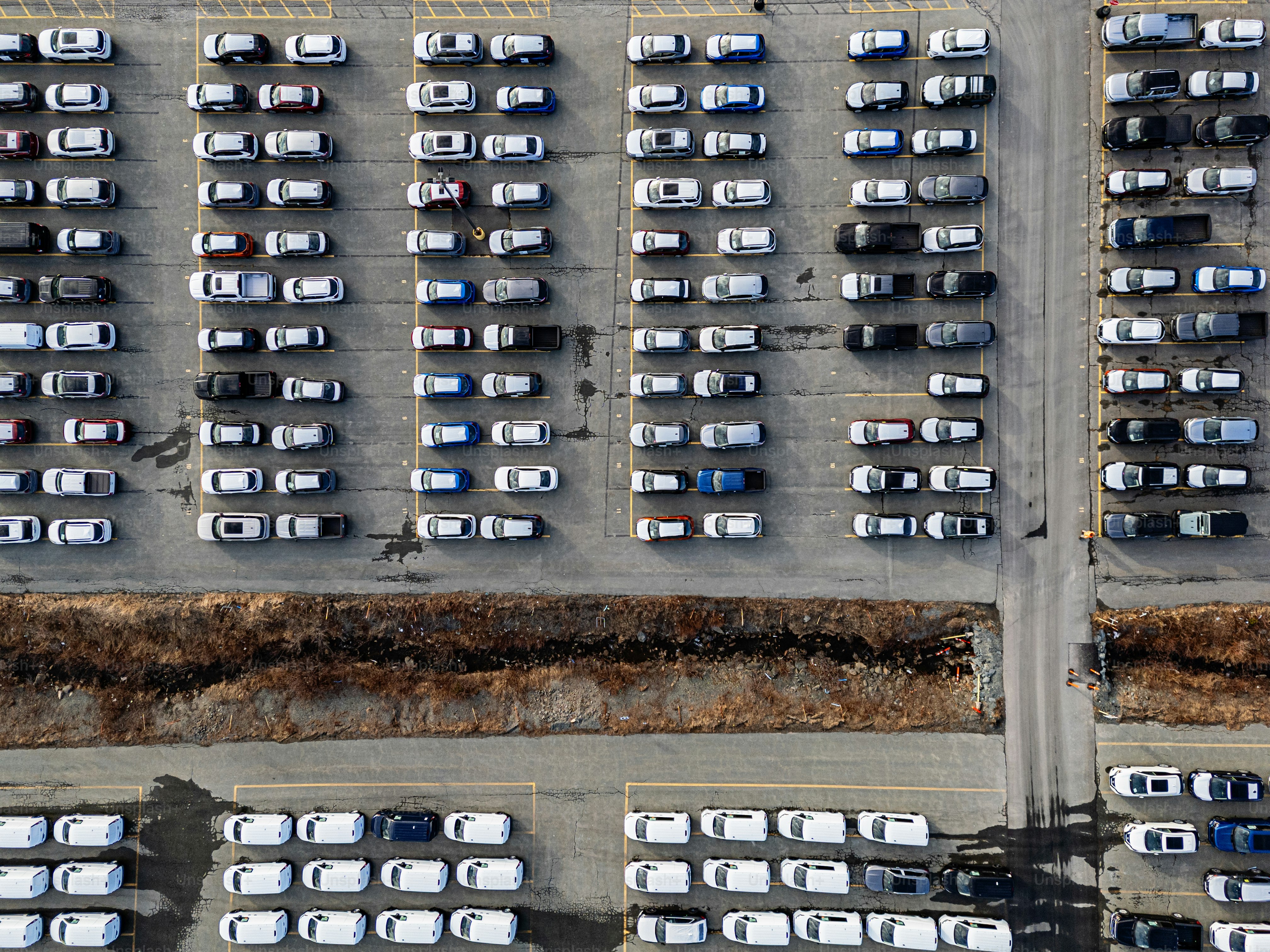 Aerial view of a large autoport where vehicles are transported by rail ...