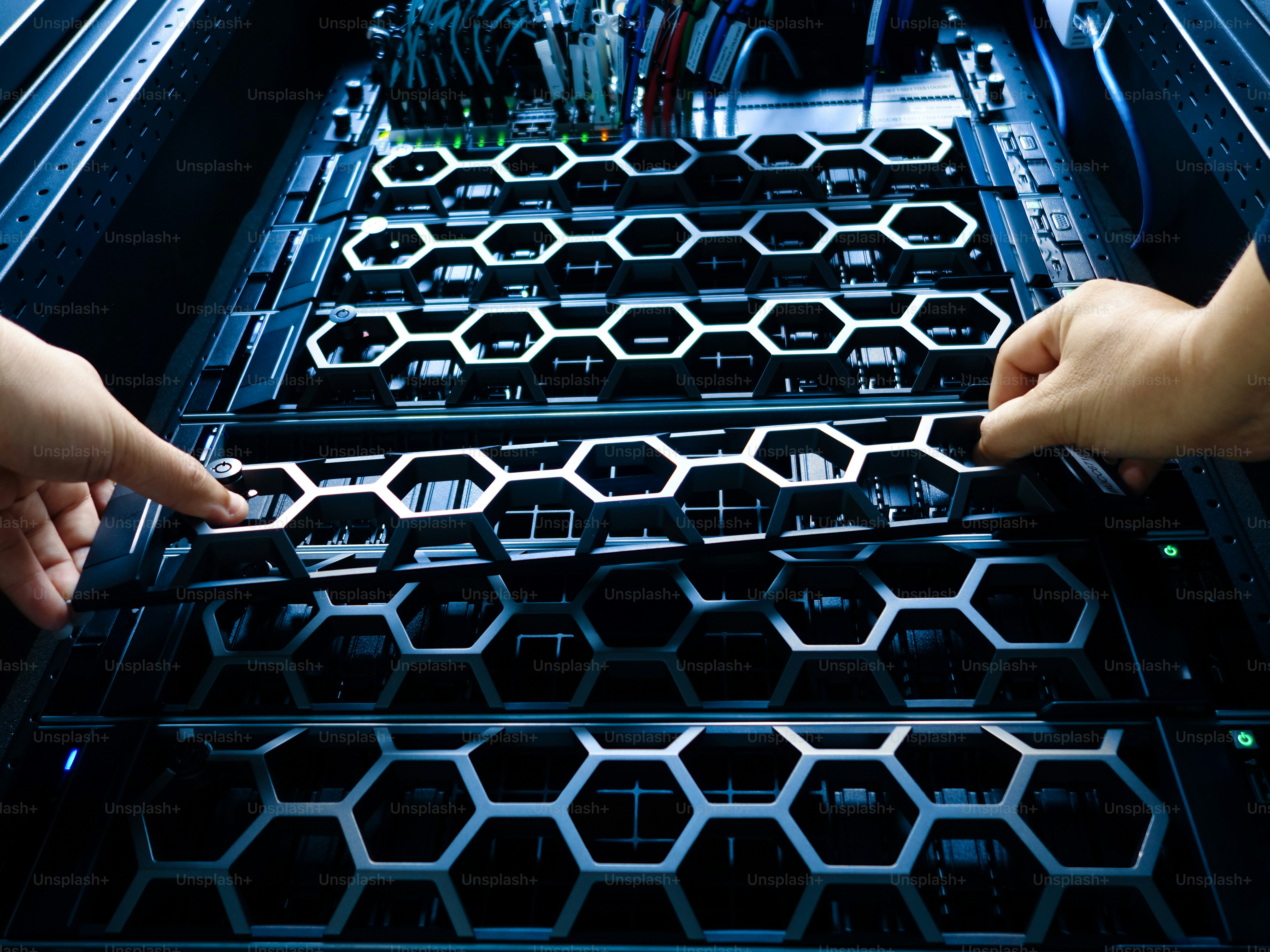 Primer plano de manos trabajando en un rack de servidores en un centro ...