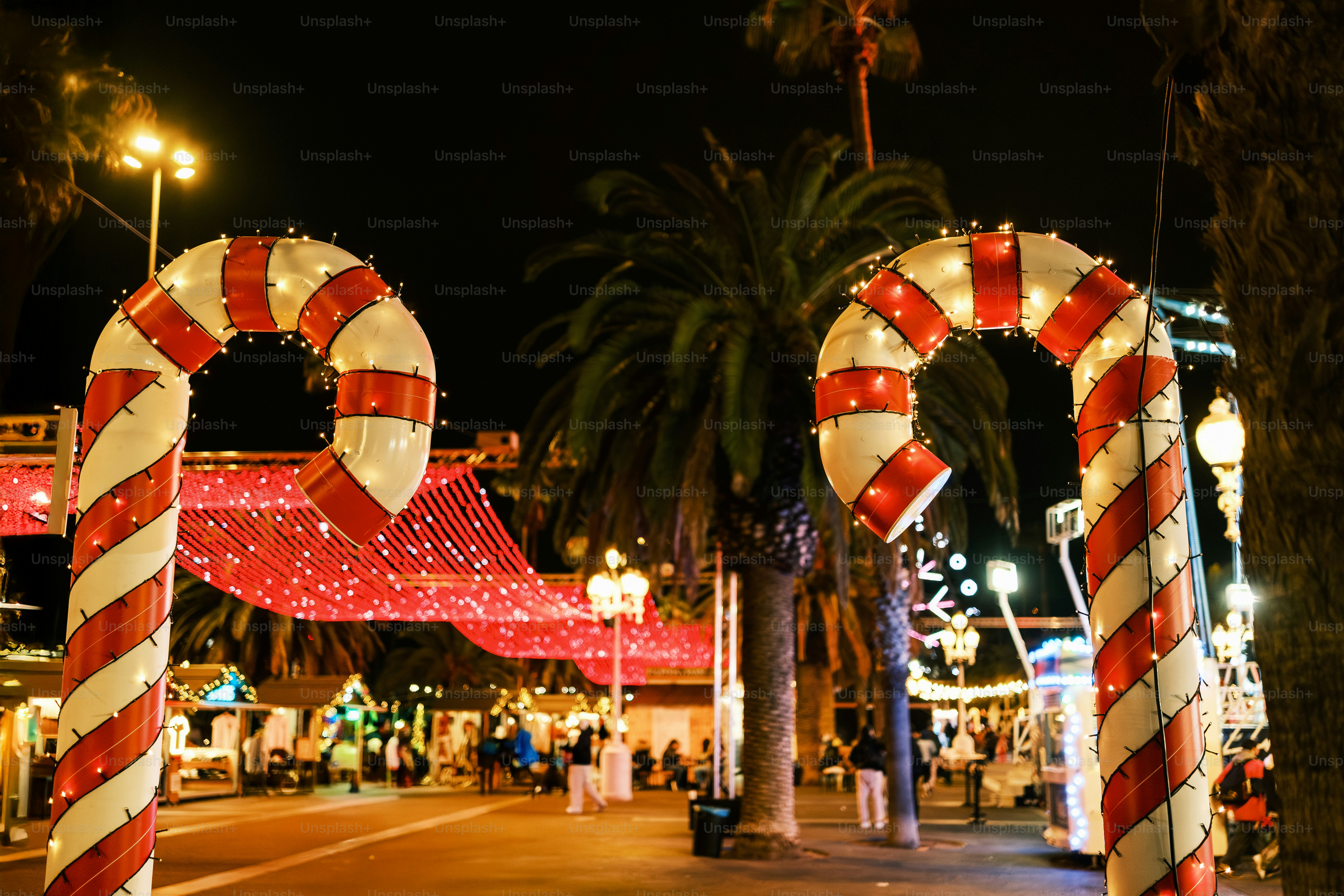 Giant candy canes light up a festive night street. photo – Christmas ...