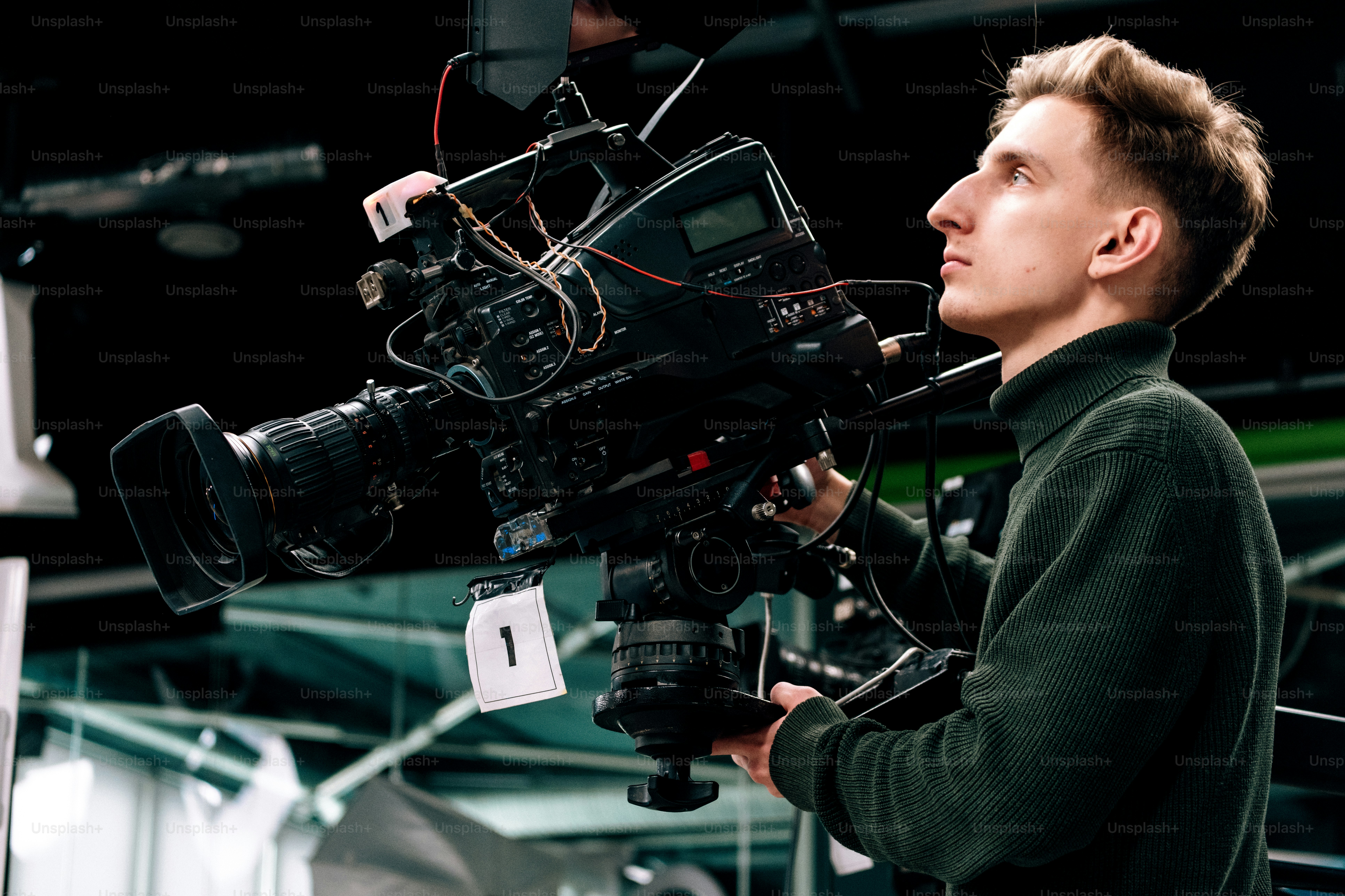 Man operating a professional video camera on set. photo – Camera Image ...