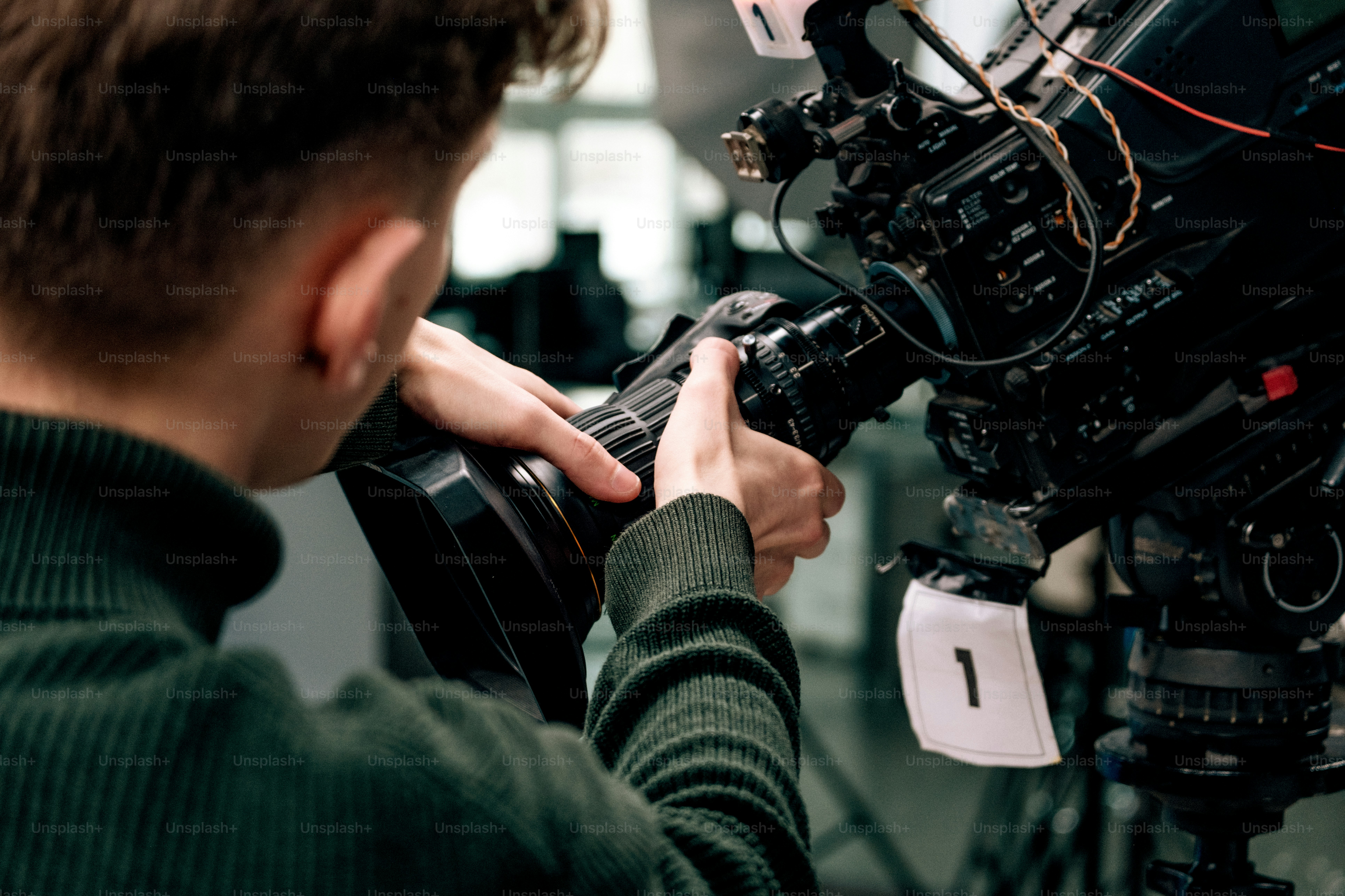 Man operating a professional video camera on set. photo – Camera Image ...