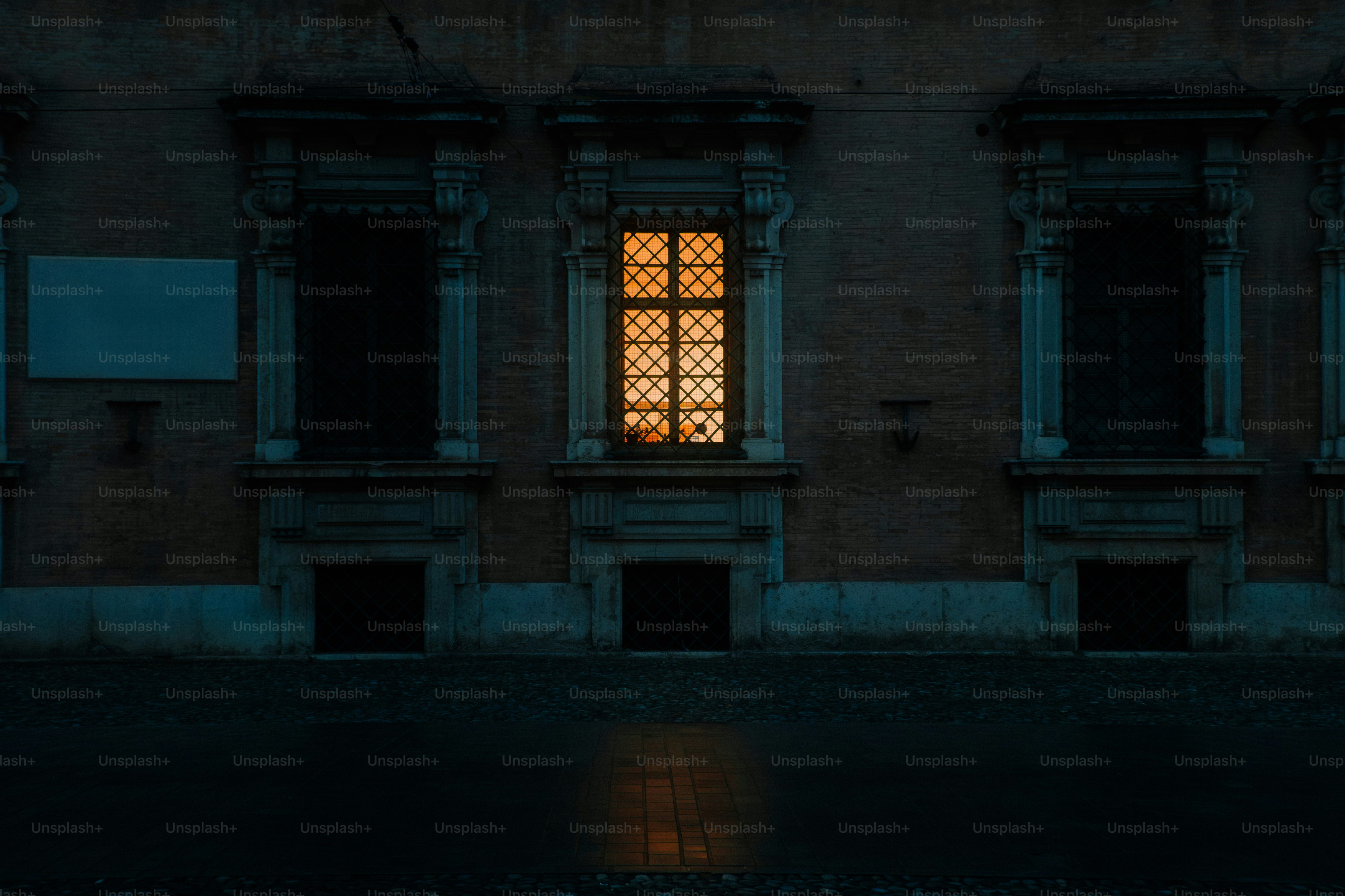 Building facade with one illuminated window at night photo – Dark Image ...