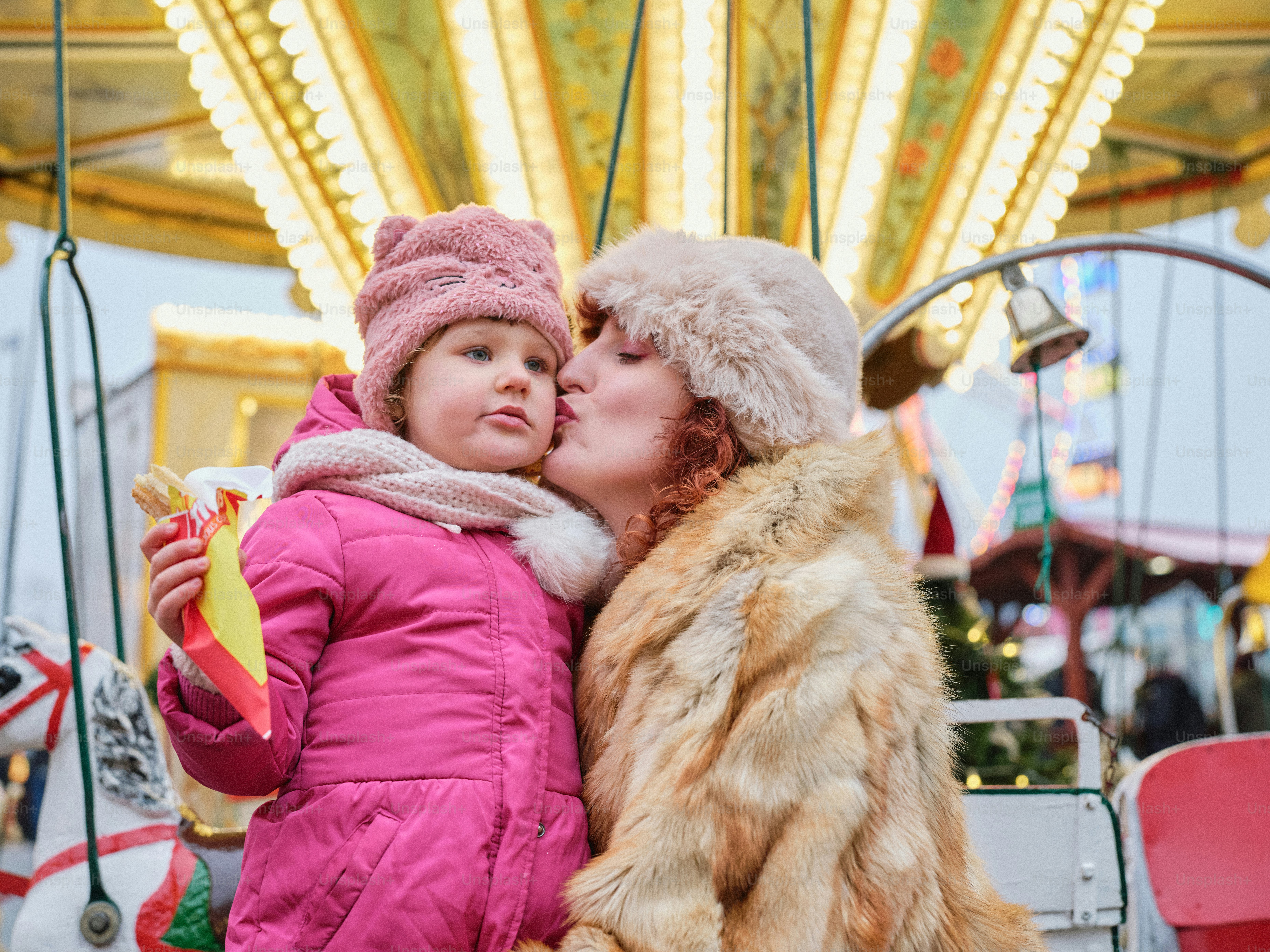 Woman feeding child on a carousel ride photo – Christmas Image on Unsplash