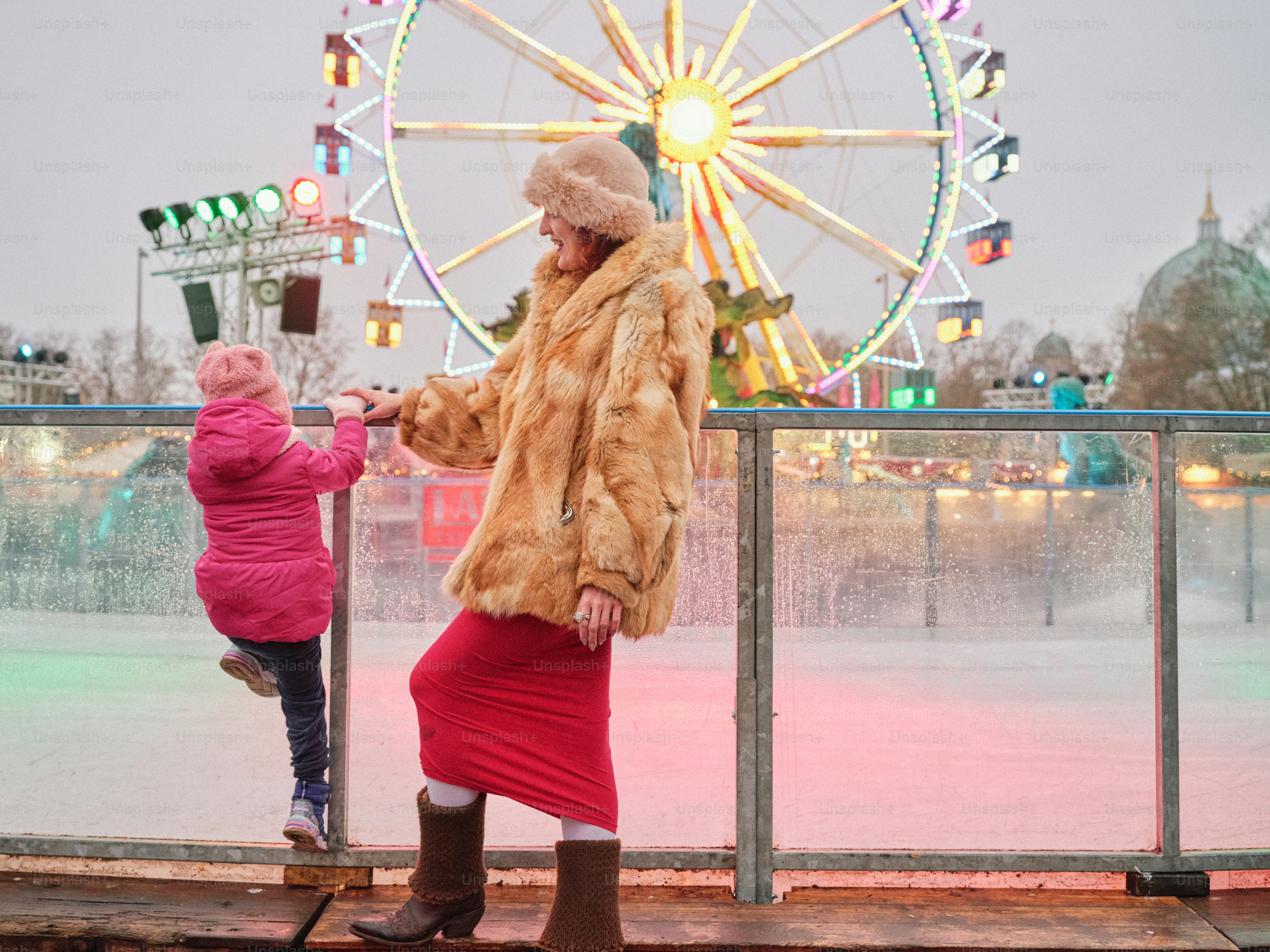 Woman and child by ferris wheel on ice rink photo – Christmas Image on ...