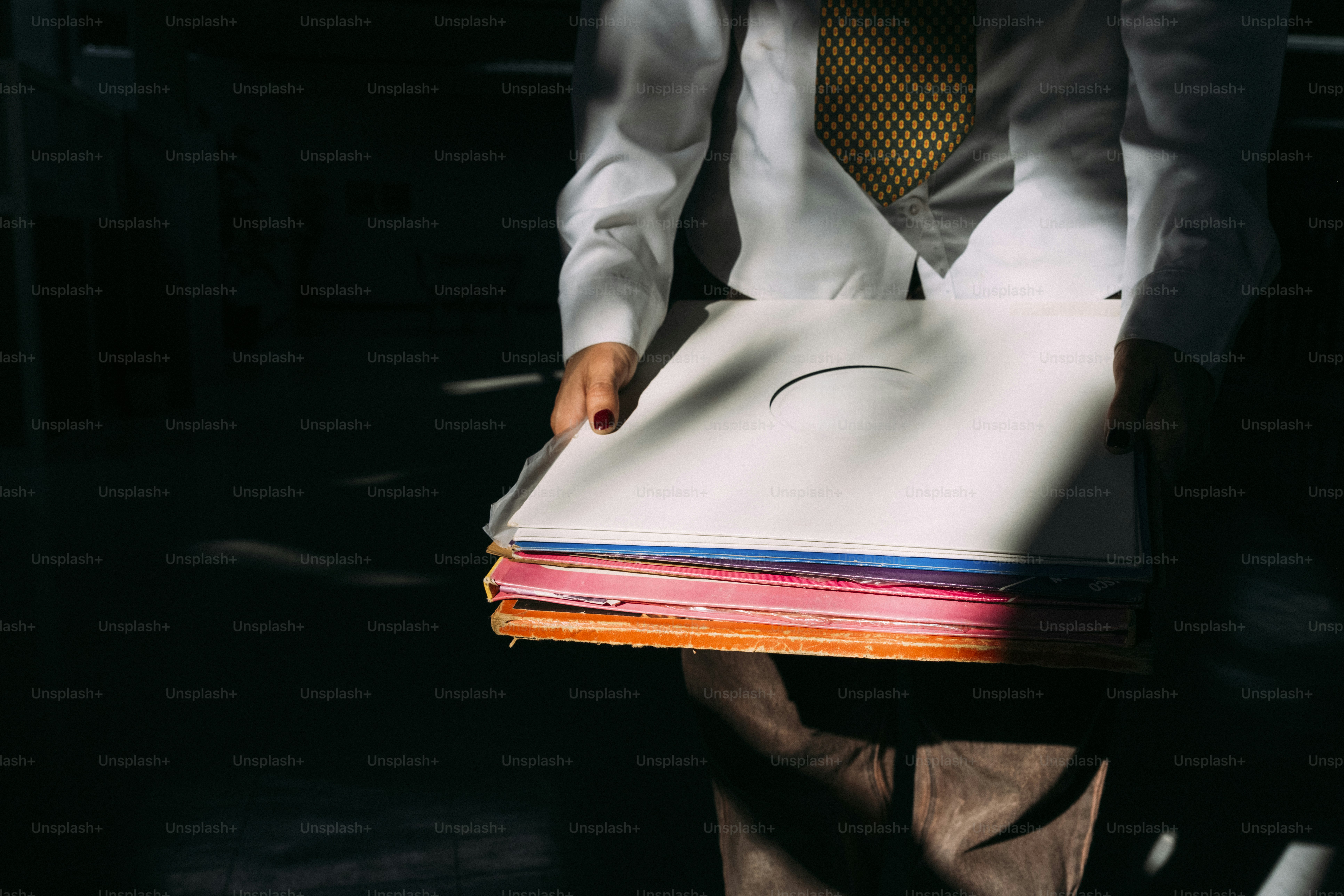 Person holding a stack of colorful files. photo – Music Image on Unsplash