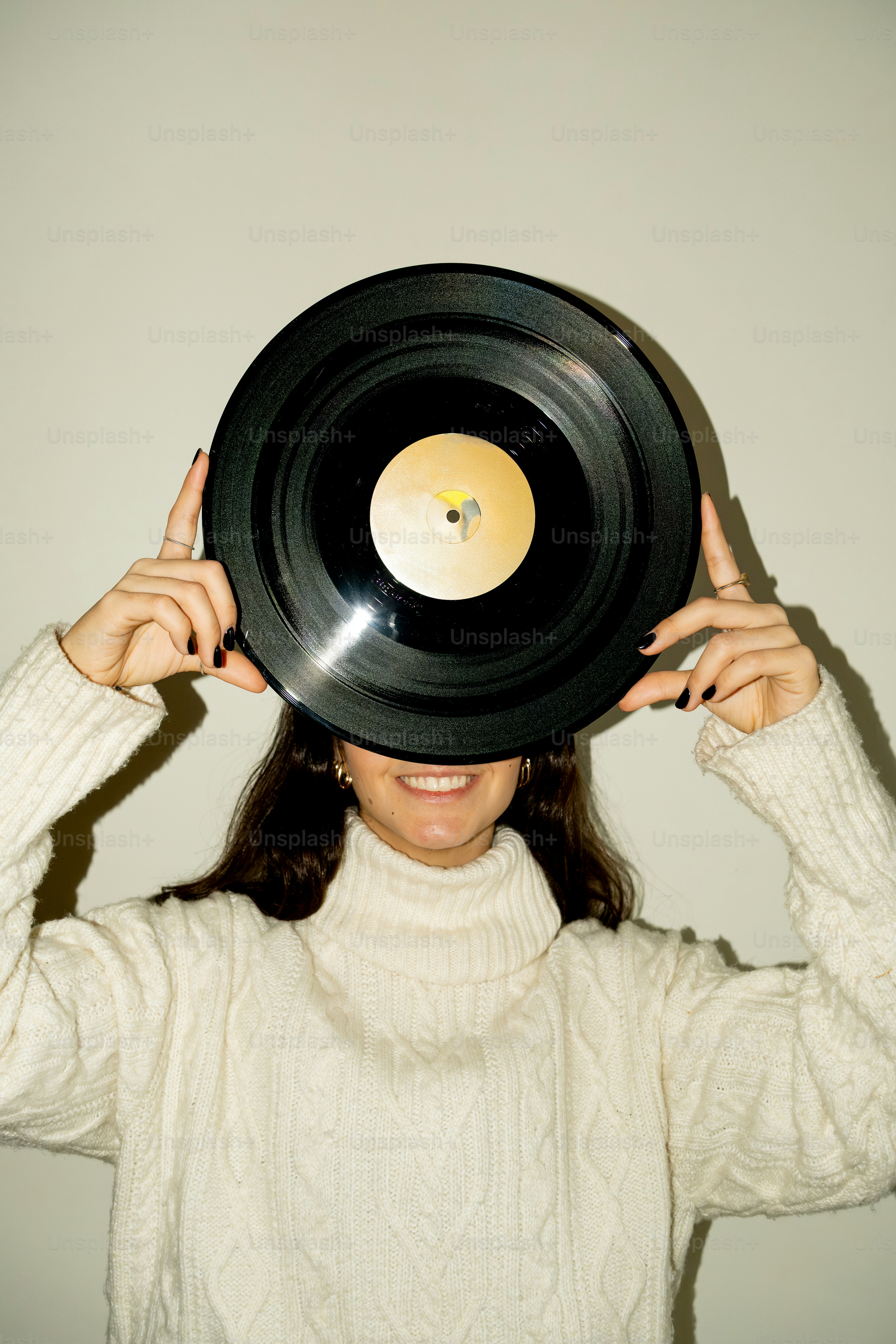 Woman holding a vinyl record over her face photo – Smiling Image on ...