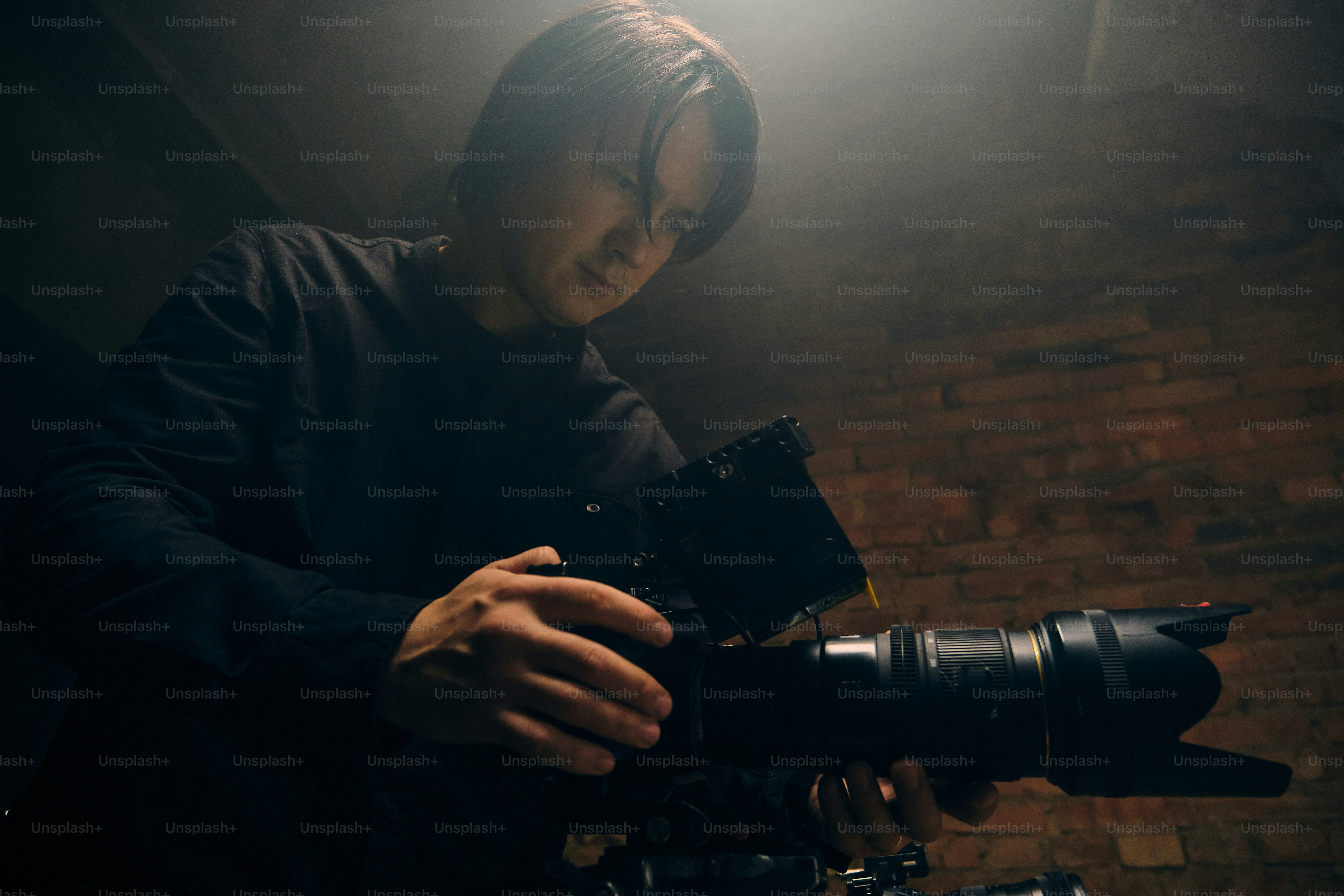 A person adjusting a professional video camera photo – Advertising ...