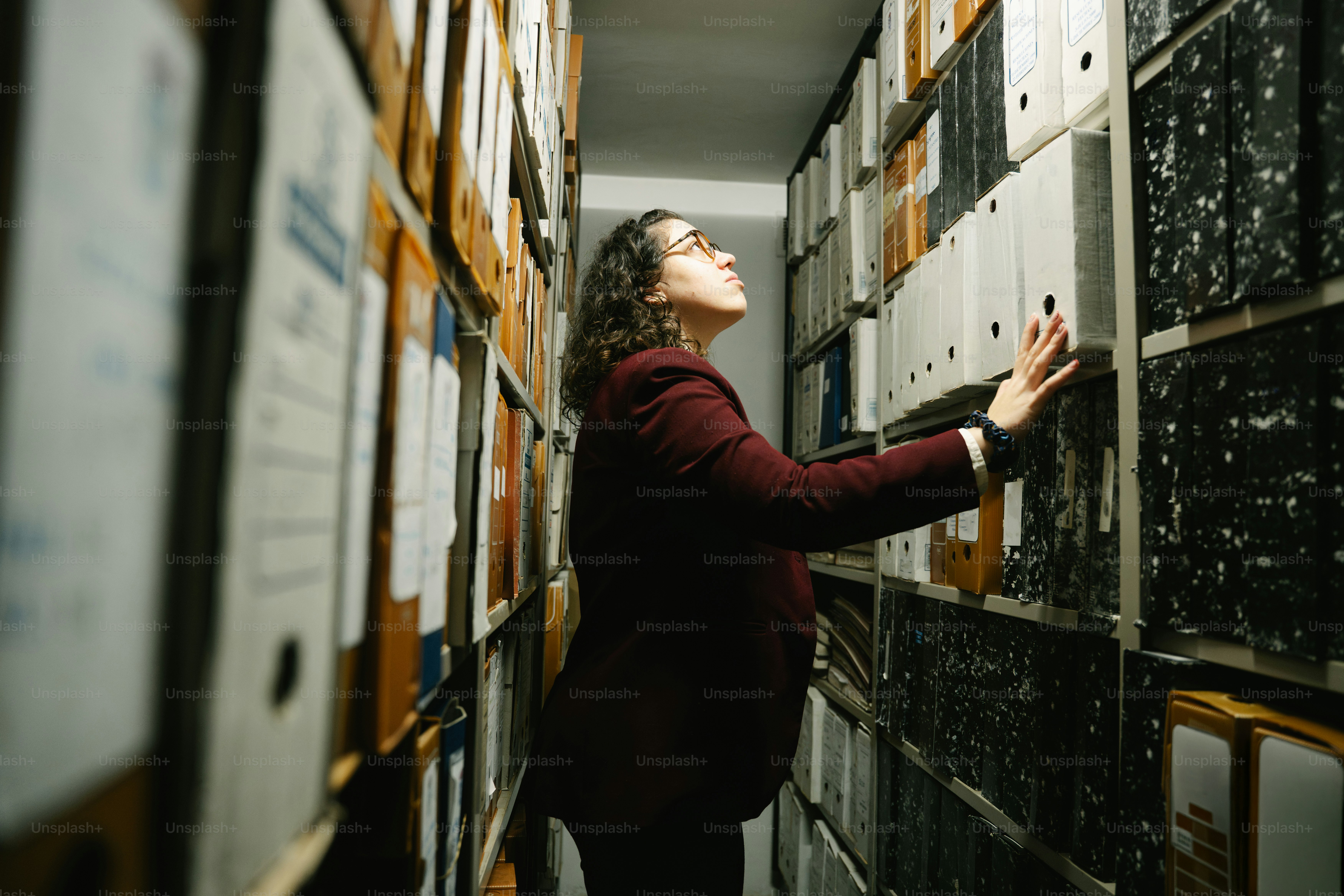Woman searching through old files in archive room photo – Library Image ...