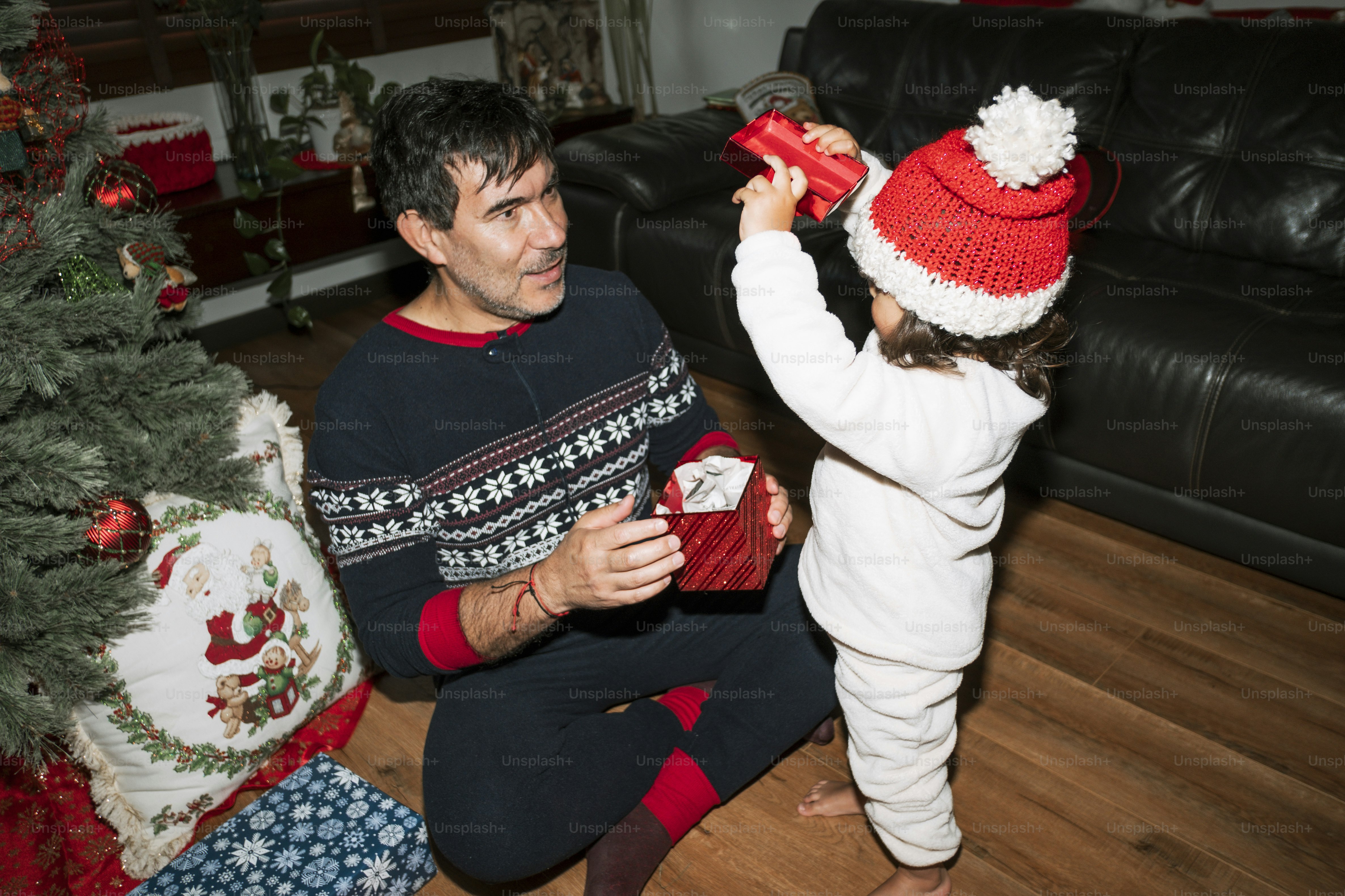 Father and child opening christmas gifts by tree photo – Christmas tree ...