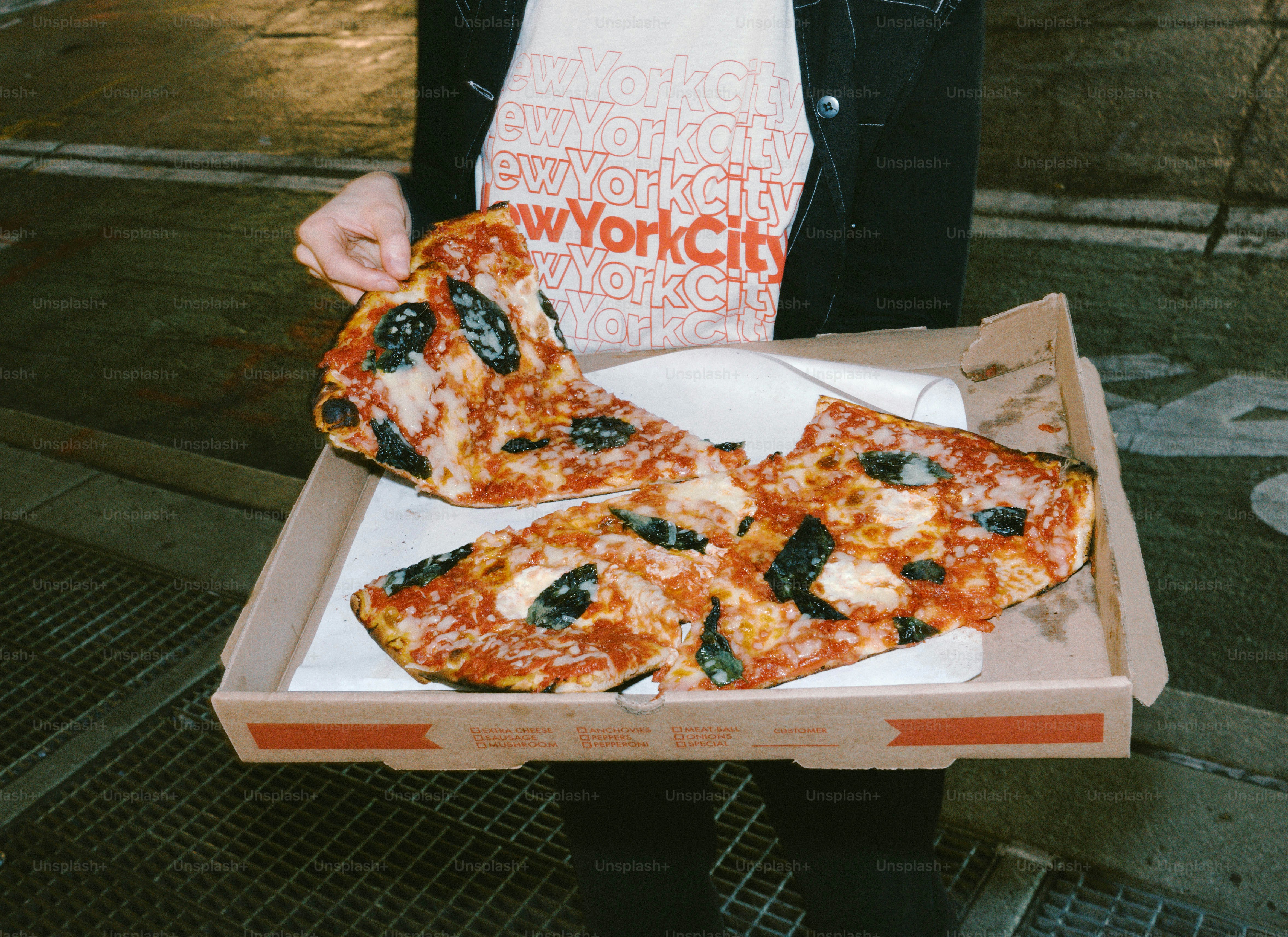 Person holding a new york city pizza box with slices photo – Pizza ...