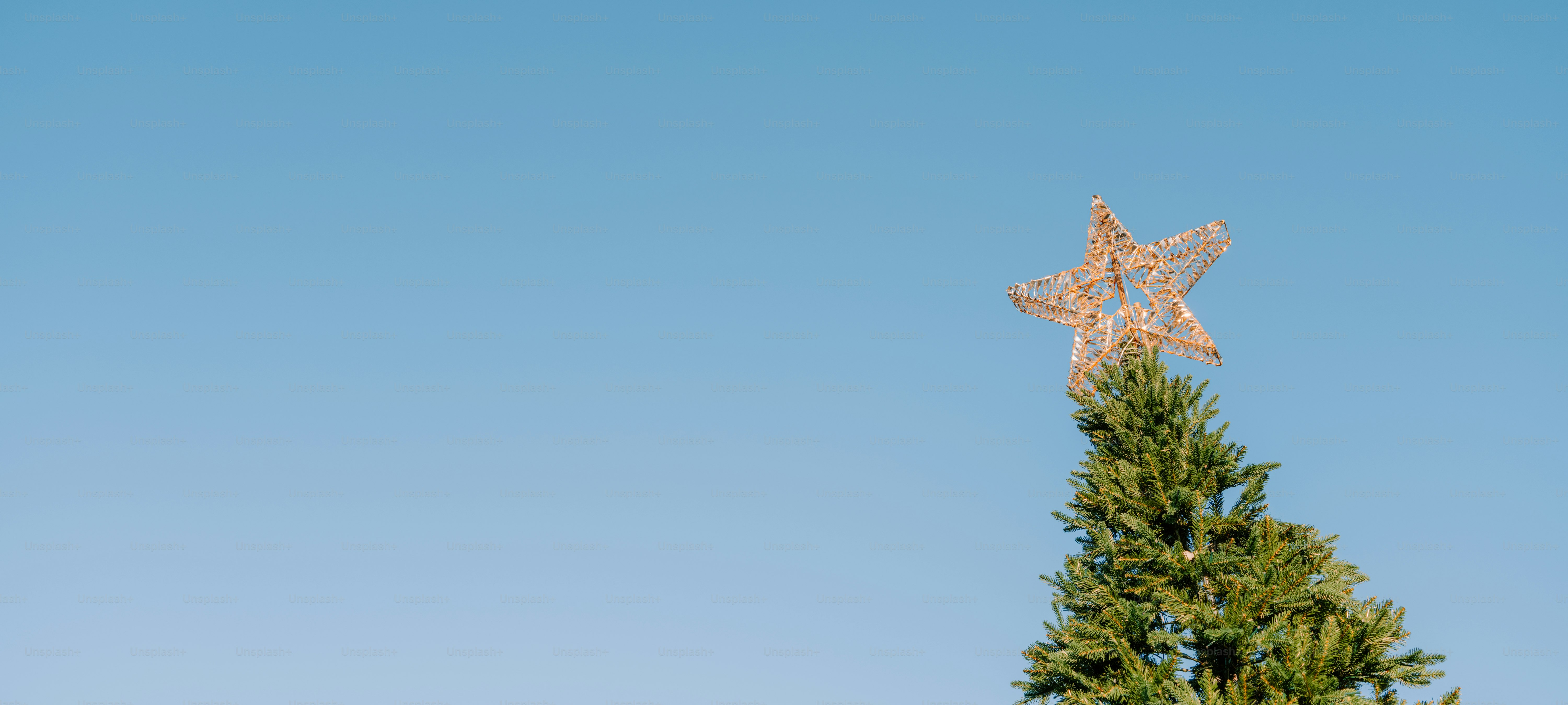 Christmas tree with star against clear blue sky photo – Winter Image on ...