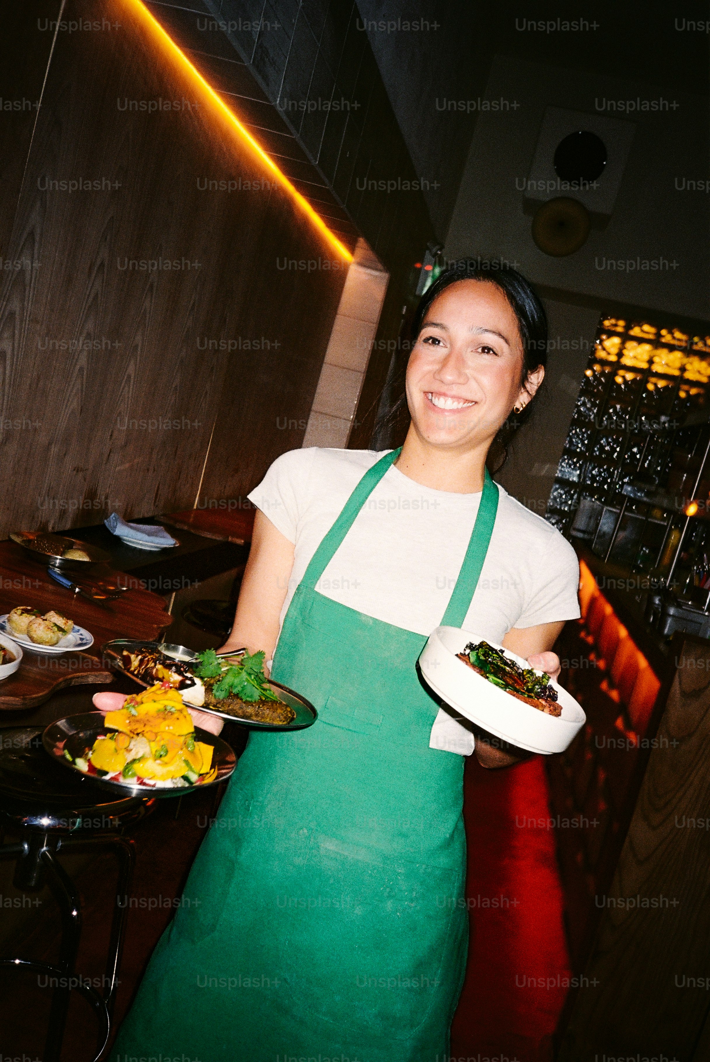 Smiling server holding two plates of food photo – Restaurant Image on ...