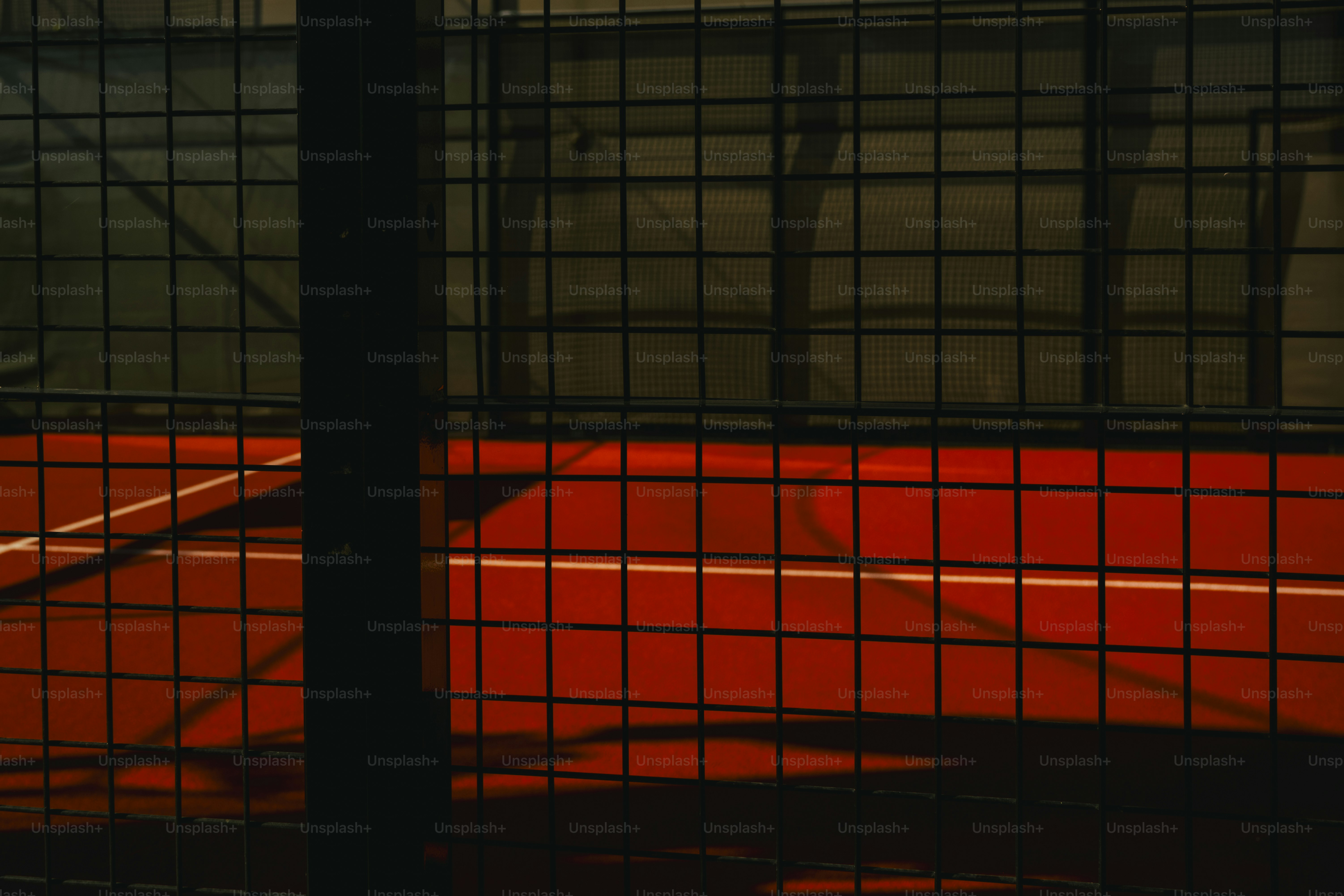 Red sports court seen through a wire fence. photo – Fitness Image on ...
