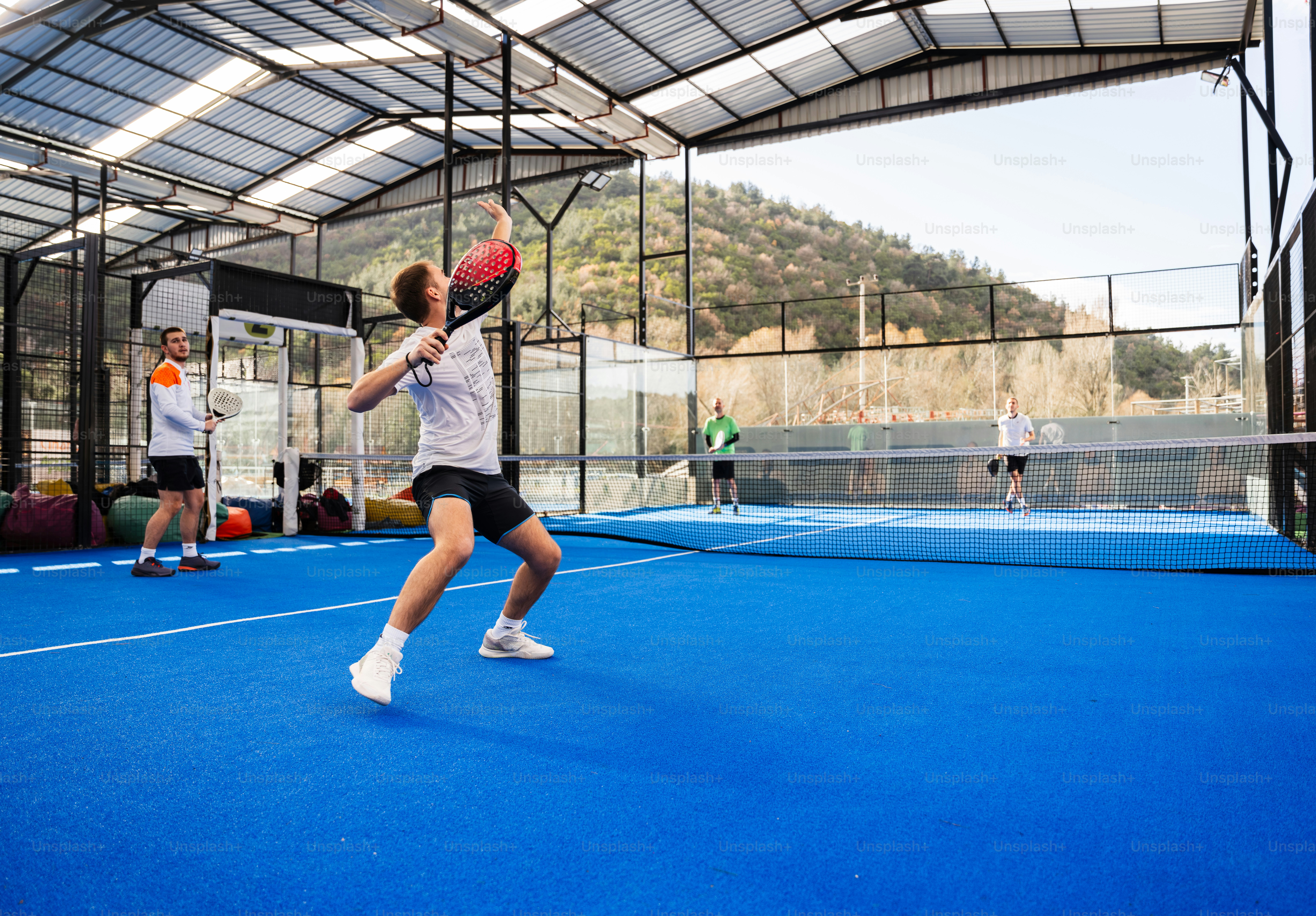 Hombre jugando al padel en una pista azul. foto – Imagen de Pádel en ...