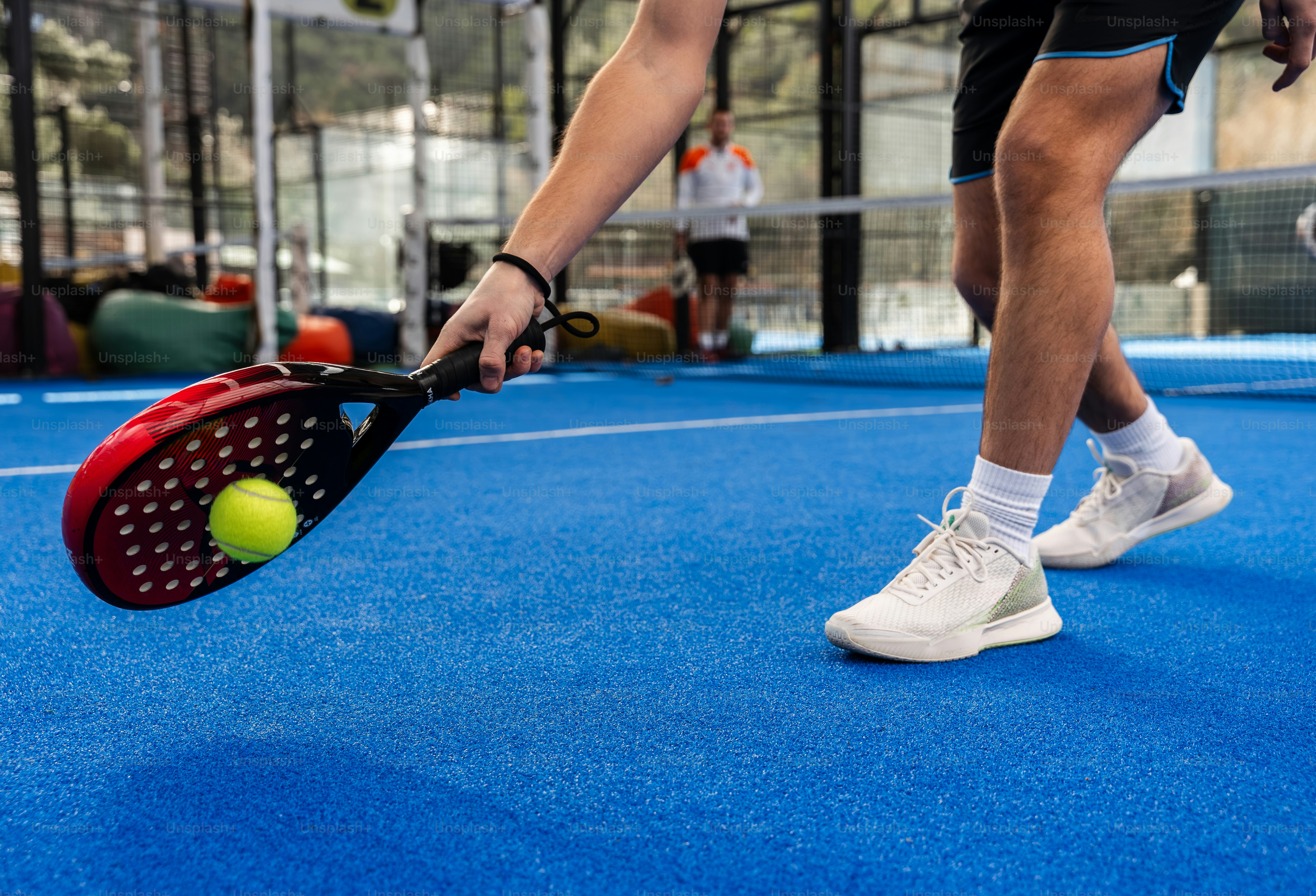 Two men playing padel tennis on a blue court. photo – Fitness Image on ...