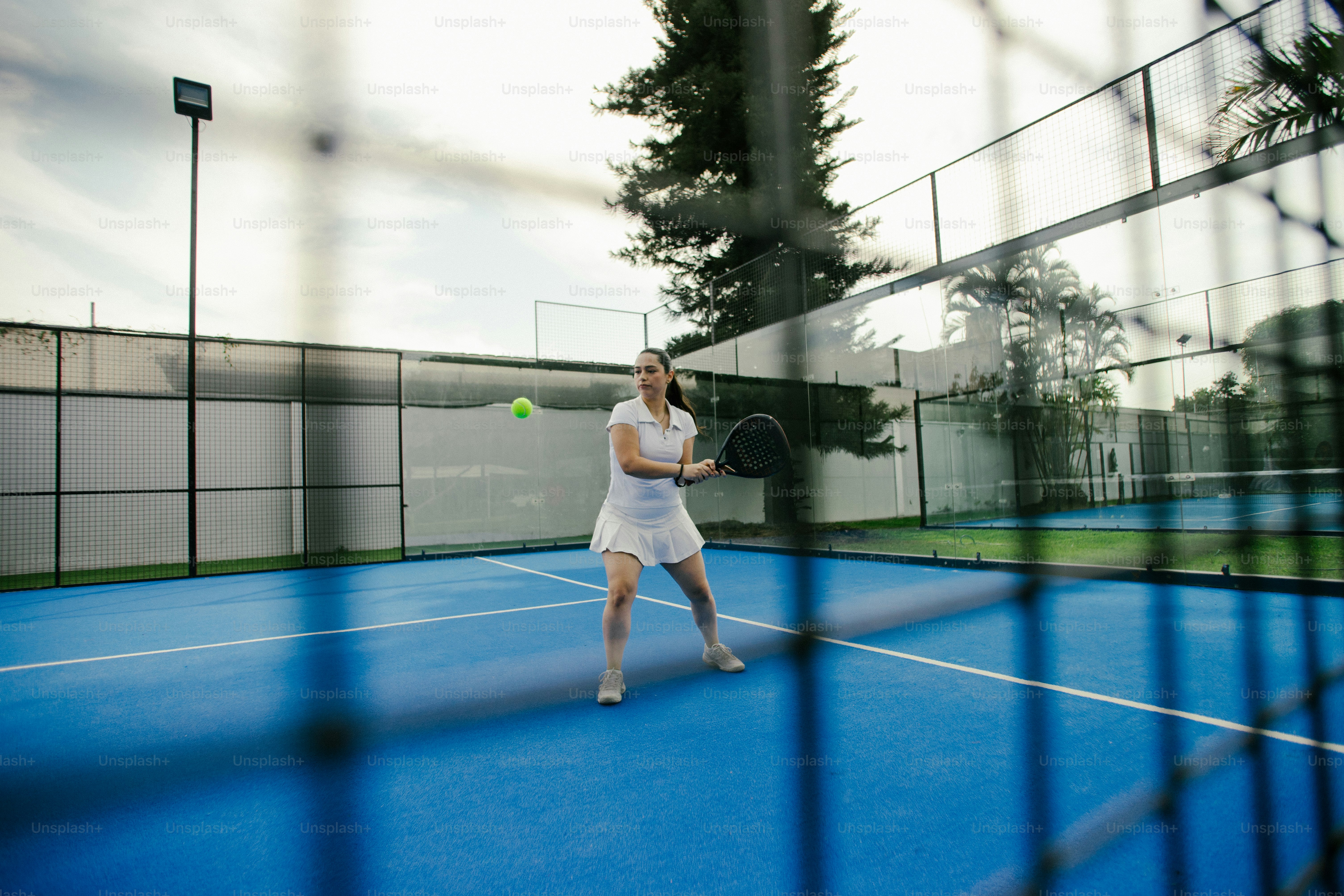 Dos personas jugando al padel en una pista azul. foto – Imagen de Pádel ...