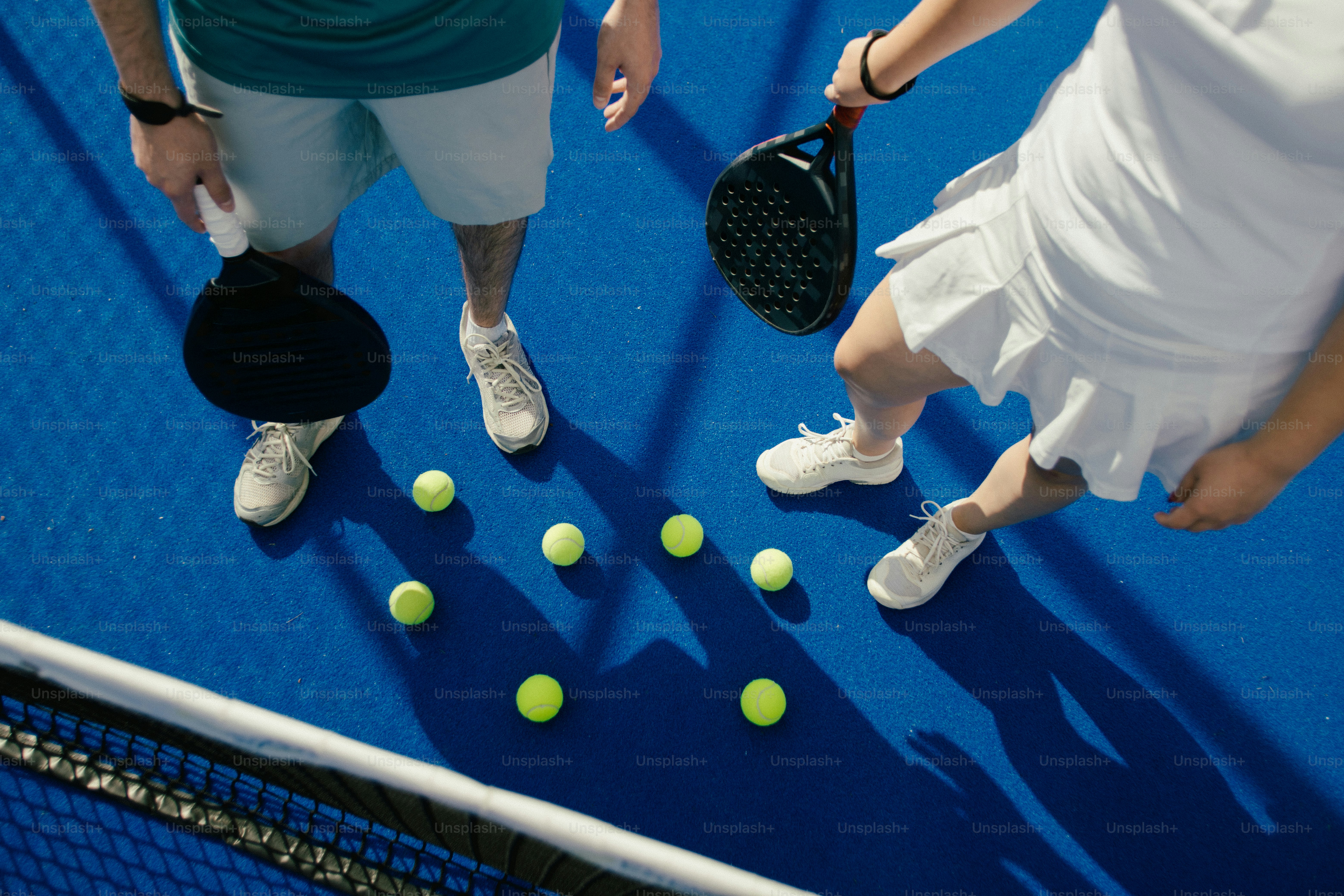 Dos personas jugando al padel con pelotas en la pista azul foto ...