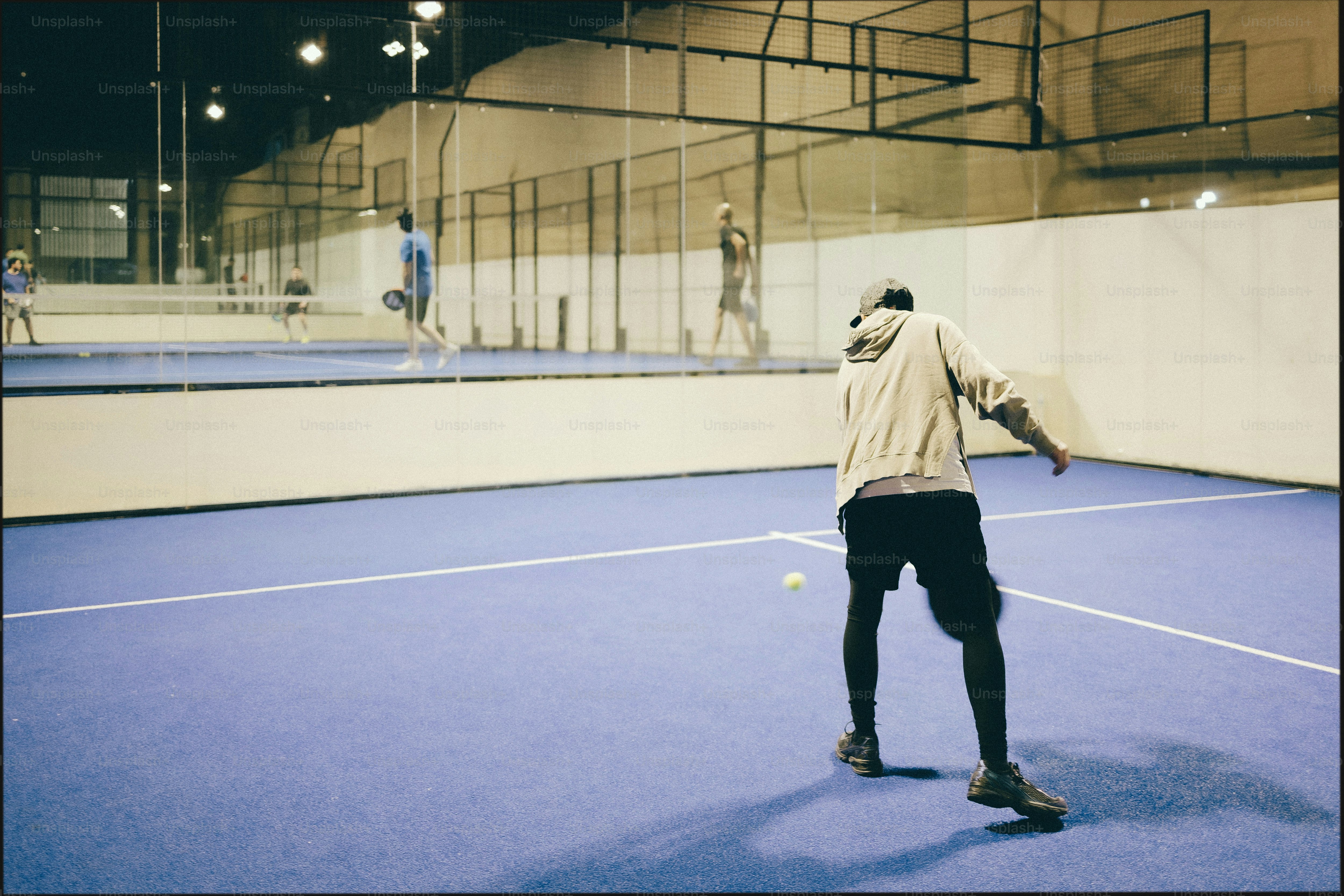 People playing padel tennis on an indoor court photo – Padel Image on ...