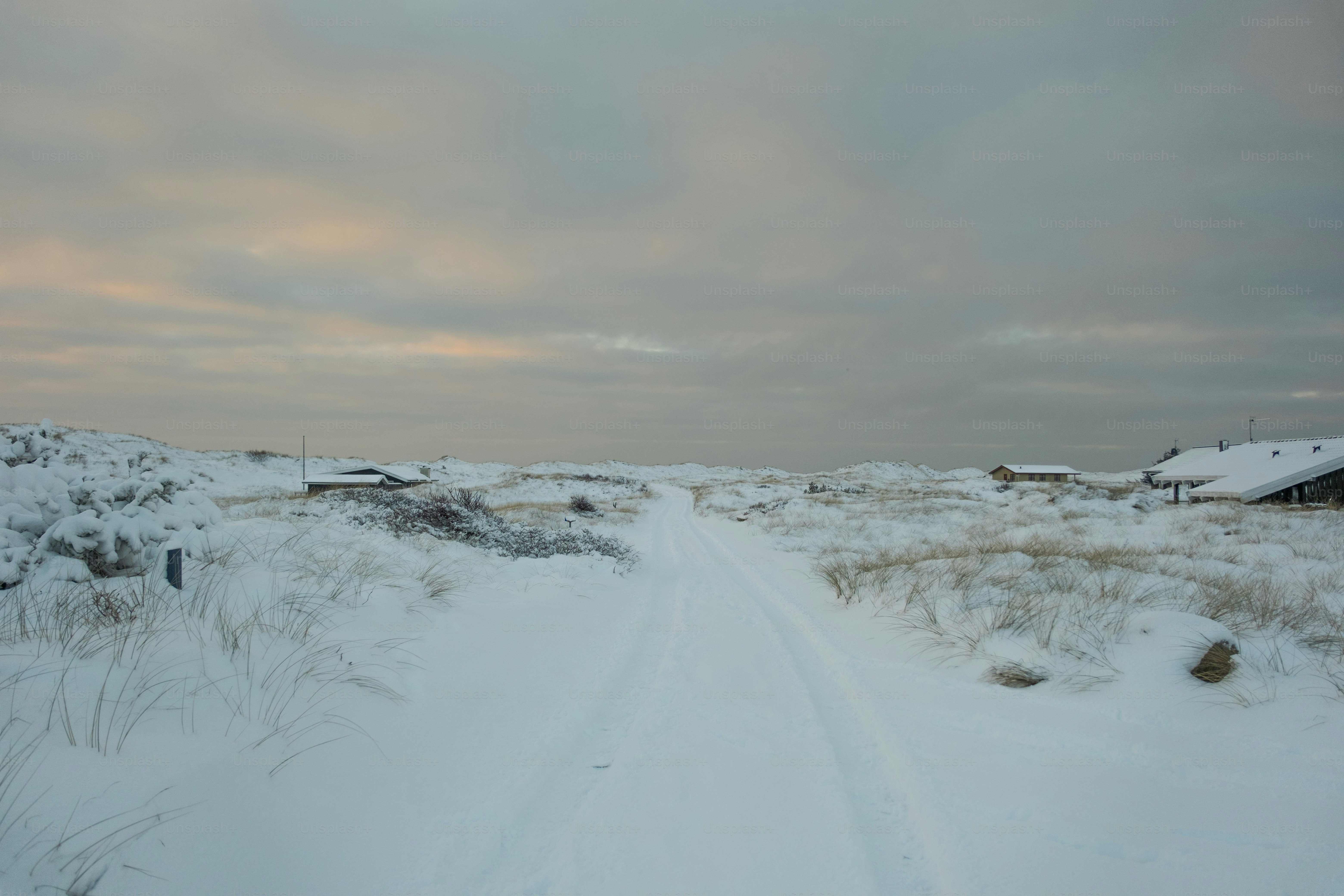 Foto Jalur bersalju melalui bukit pasir dengan bangunan yang tersebar ...