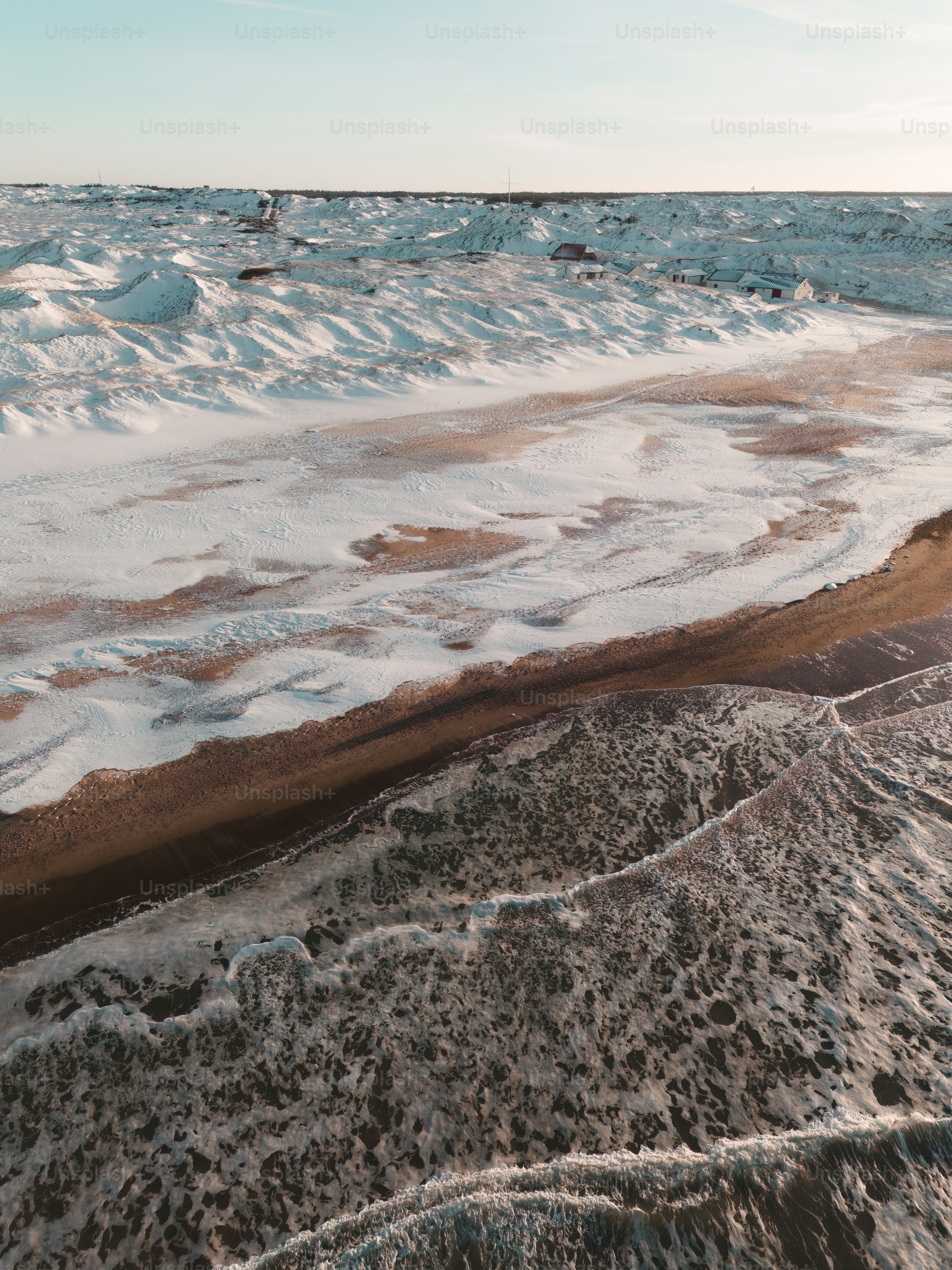 Snowy beach with waves crashing on shore photo – Beach Image on Unsplash