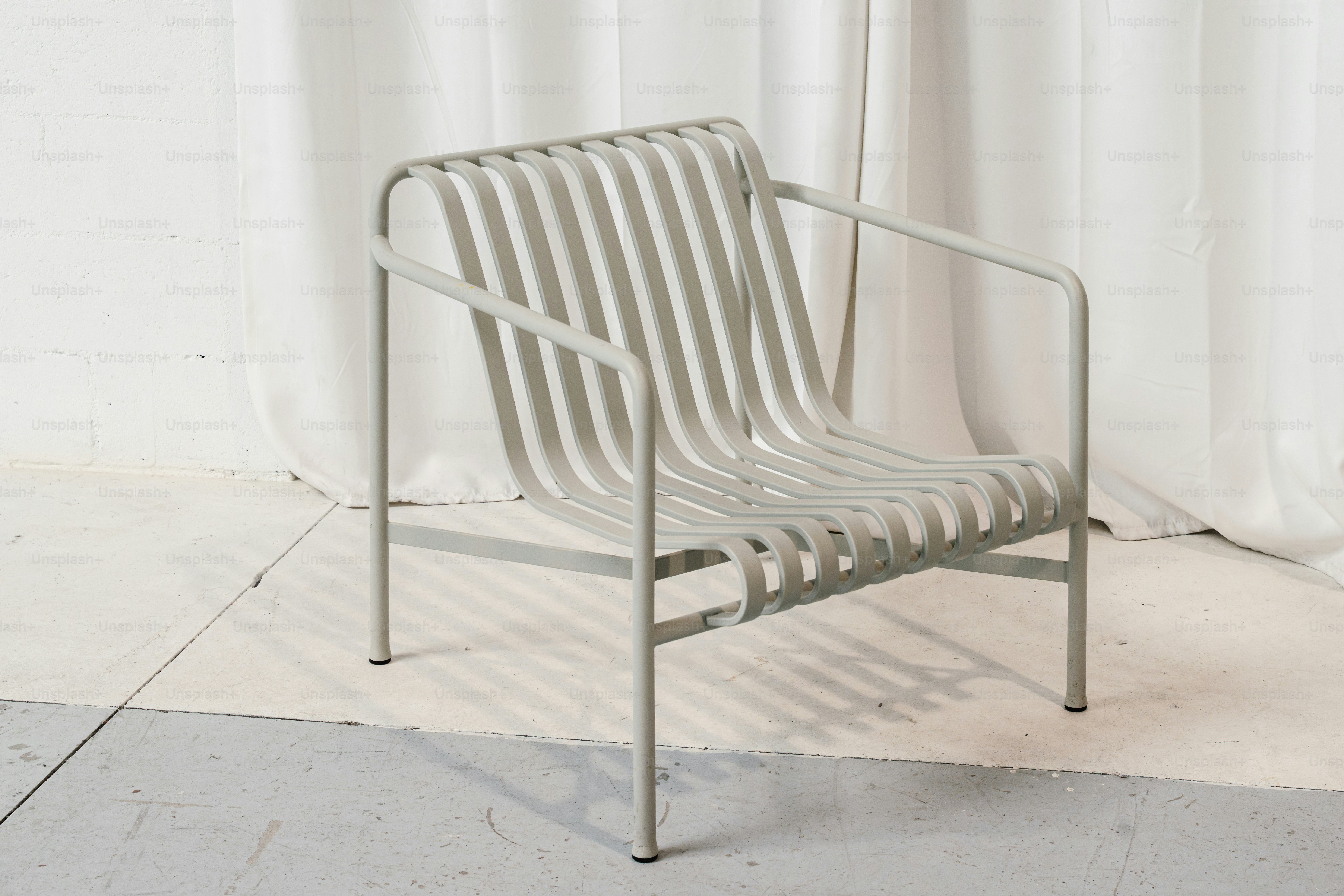 A modern grey metal chair with slatted seat and back. photo – Interior ...