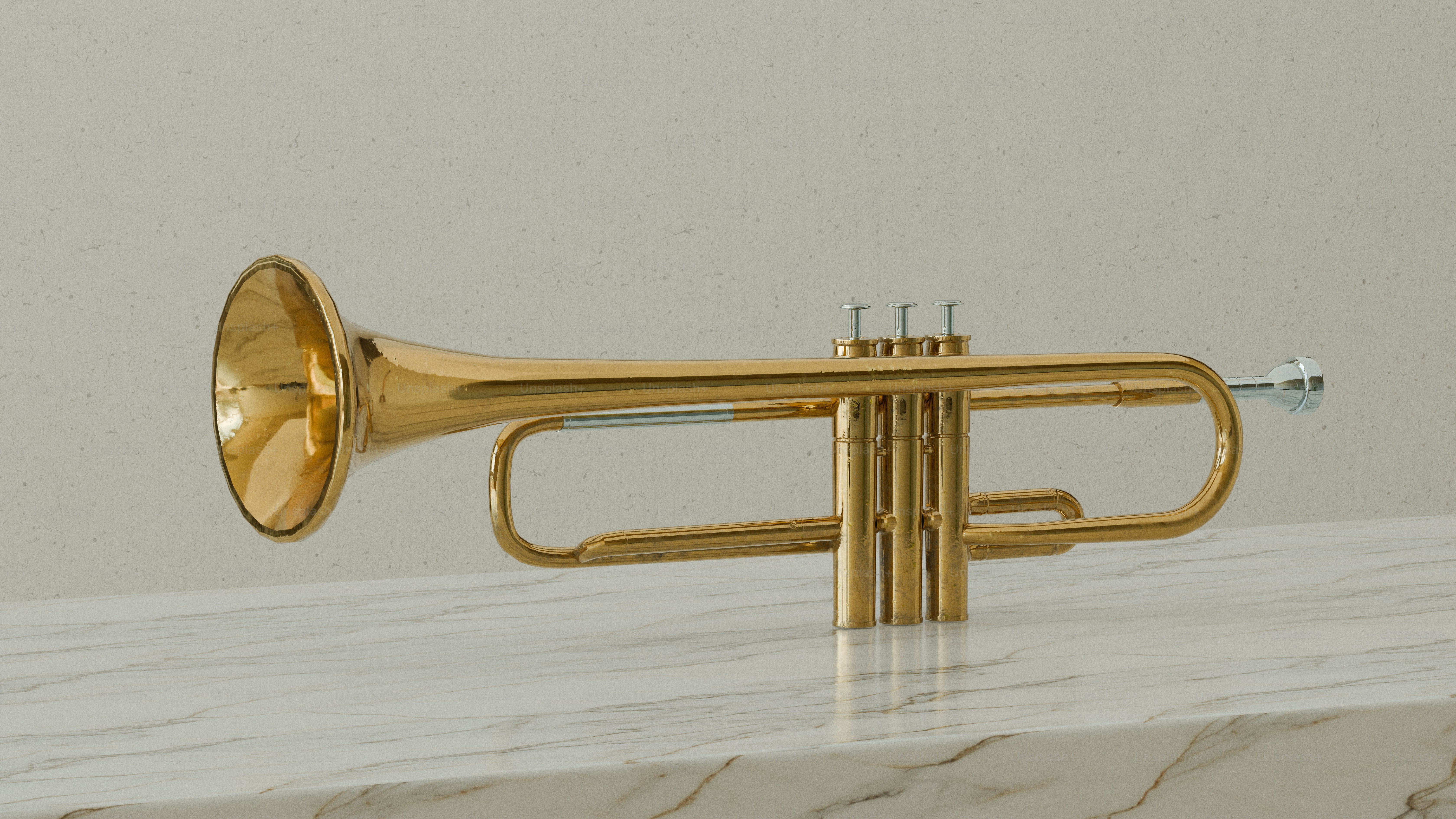 A shiny brass trumpet rests on a marble surface. photo – Music Image on ...