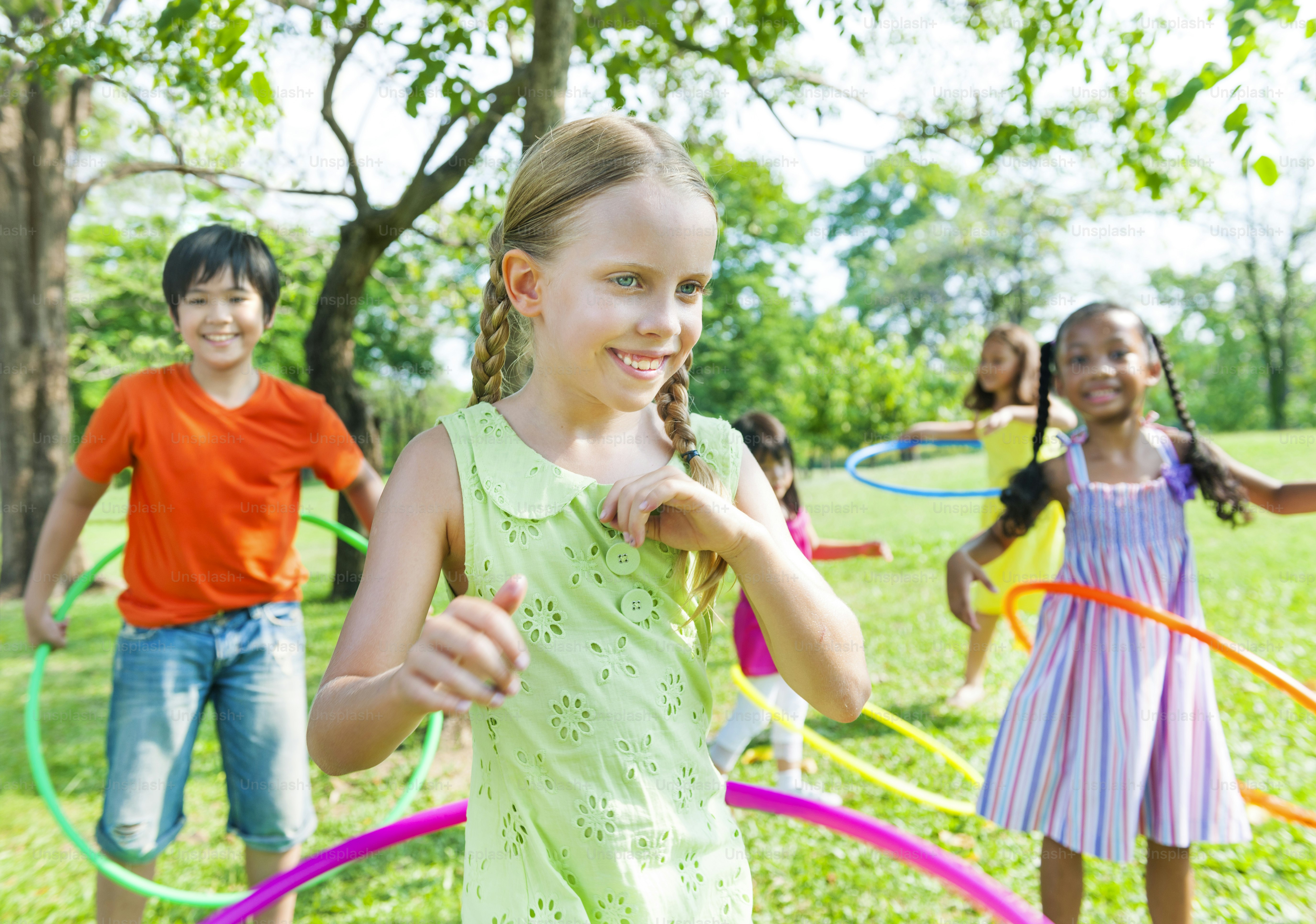 Children playing with hula hoops in a park. photo – Summer Image on ...