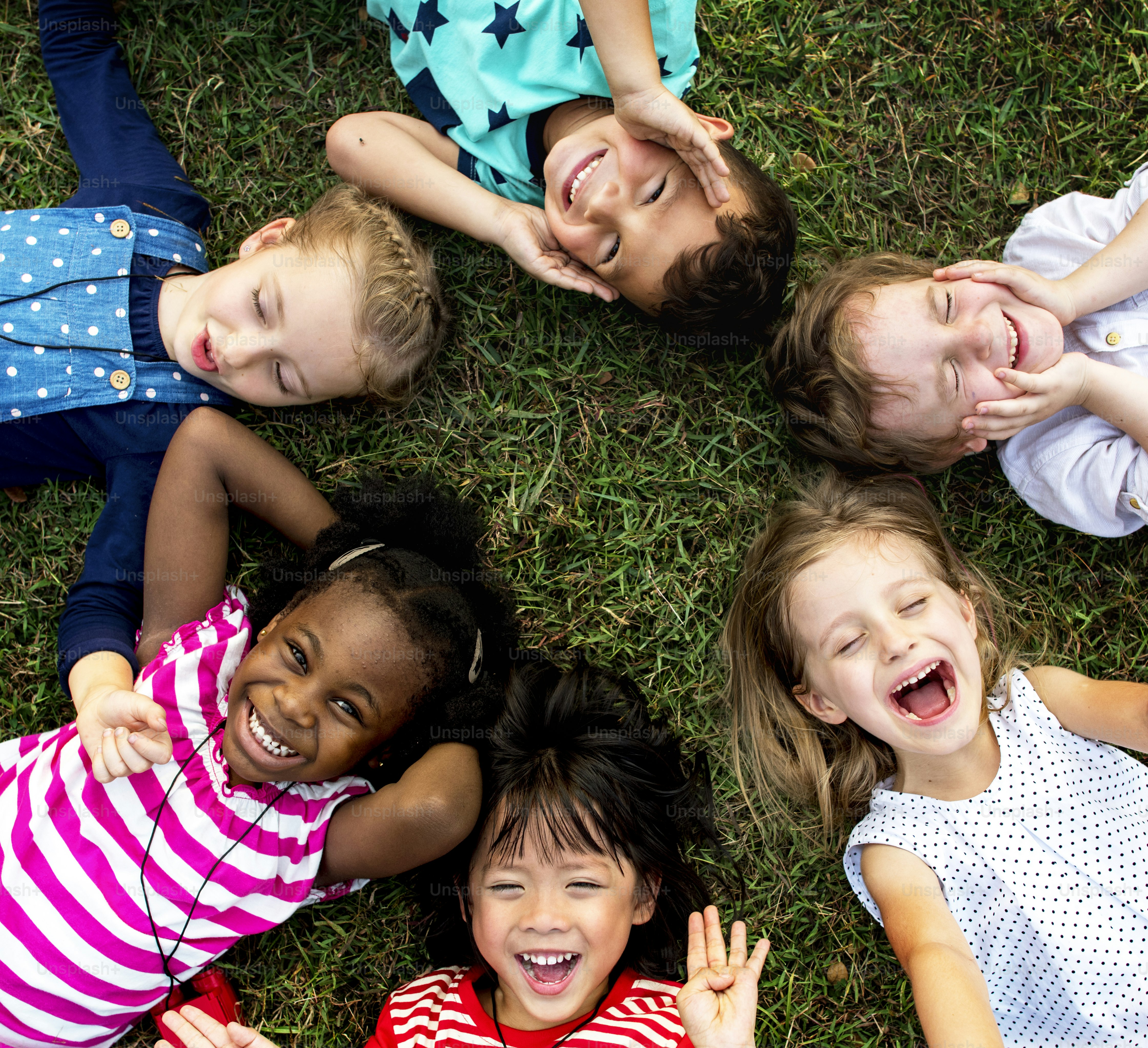 Foto Sekelompok anak-anak taman kanak-kanak berbaring di rumput di ...