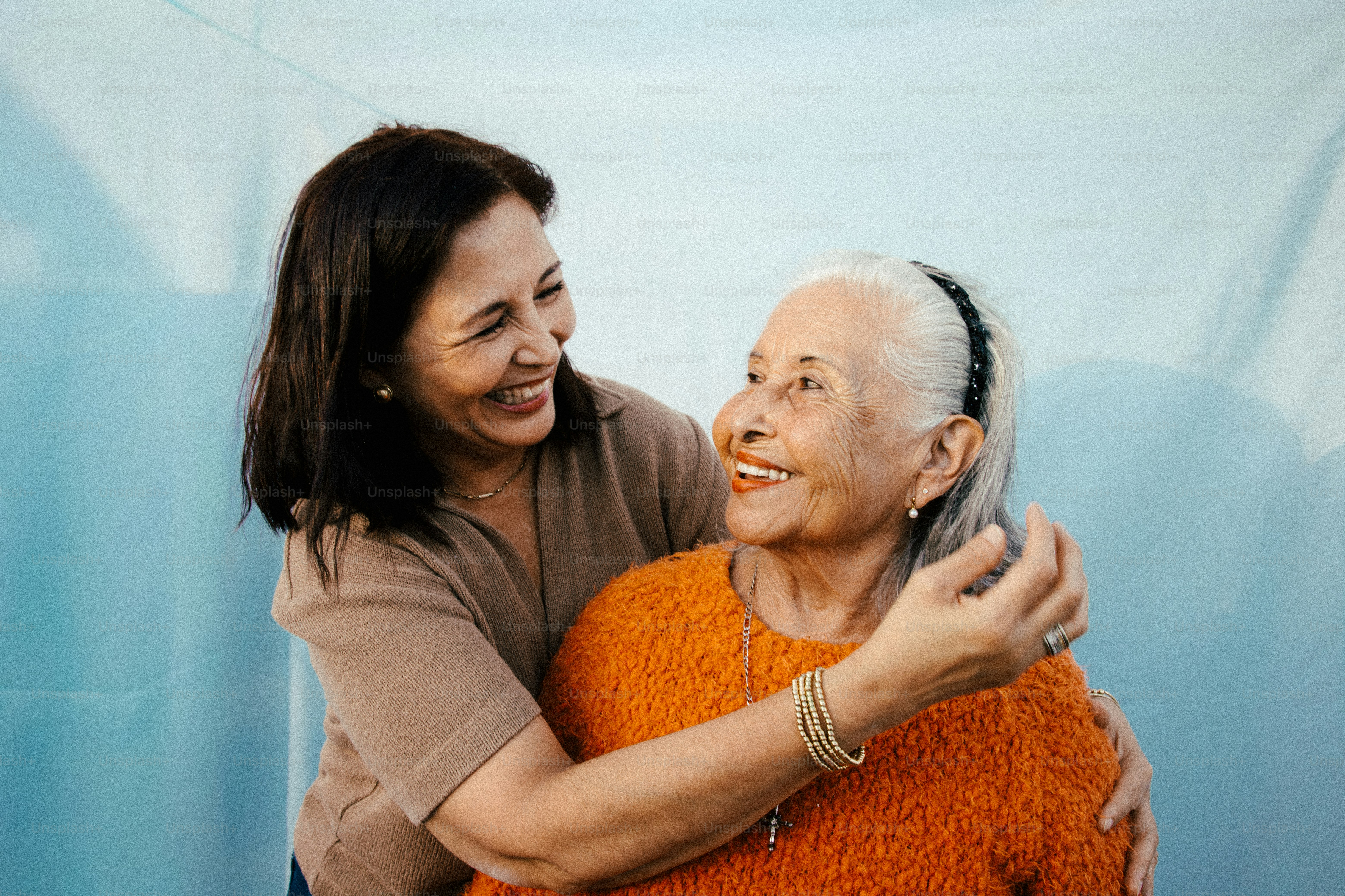 Two women, one younger, one older, embracing and smiling. photo ...