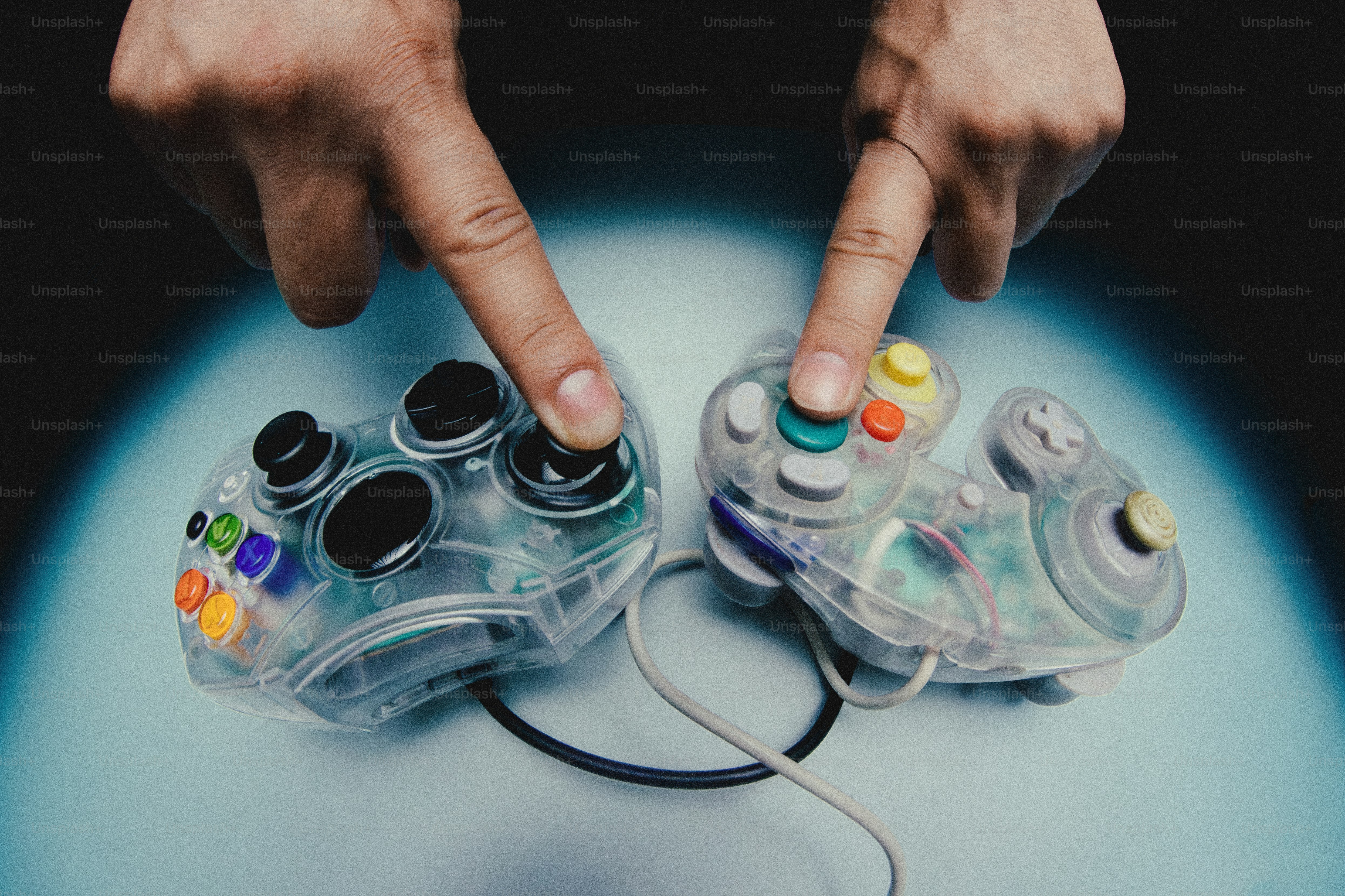 Two transparent video game controllers stacked vertically. photo ...