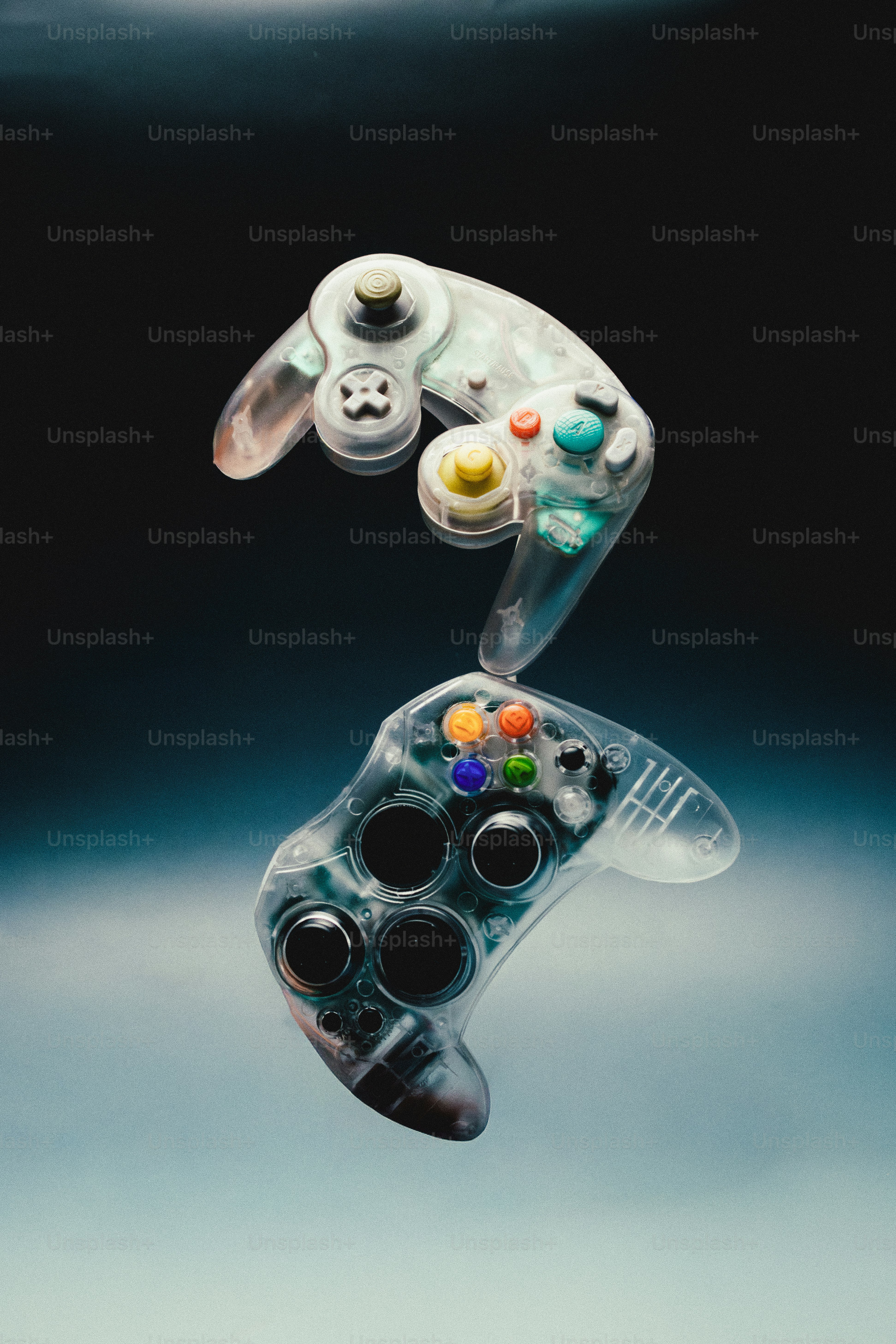 Two transparent video game controllers stacked vertically. photo ...