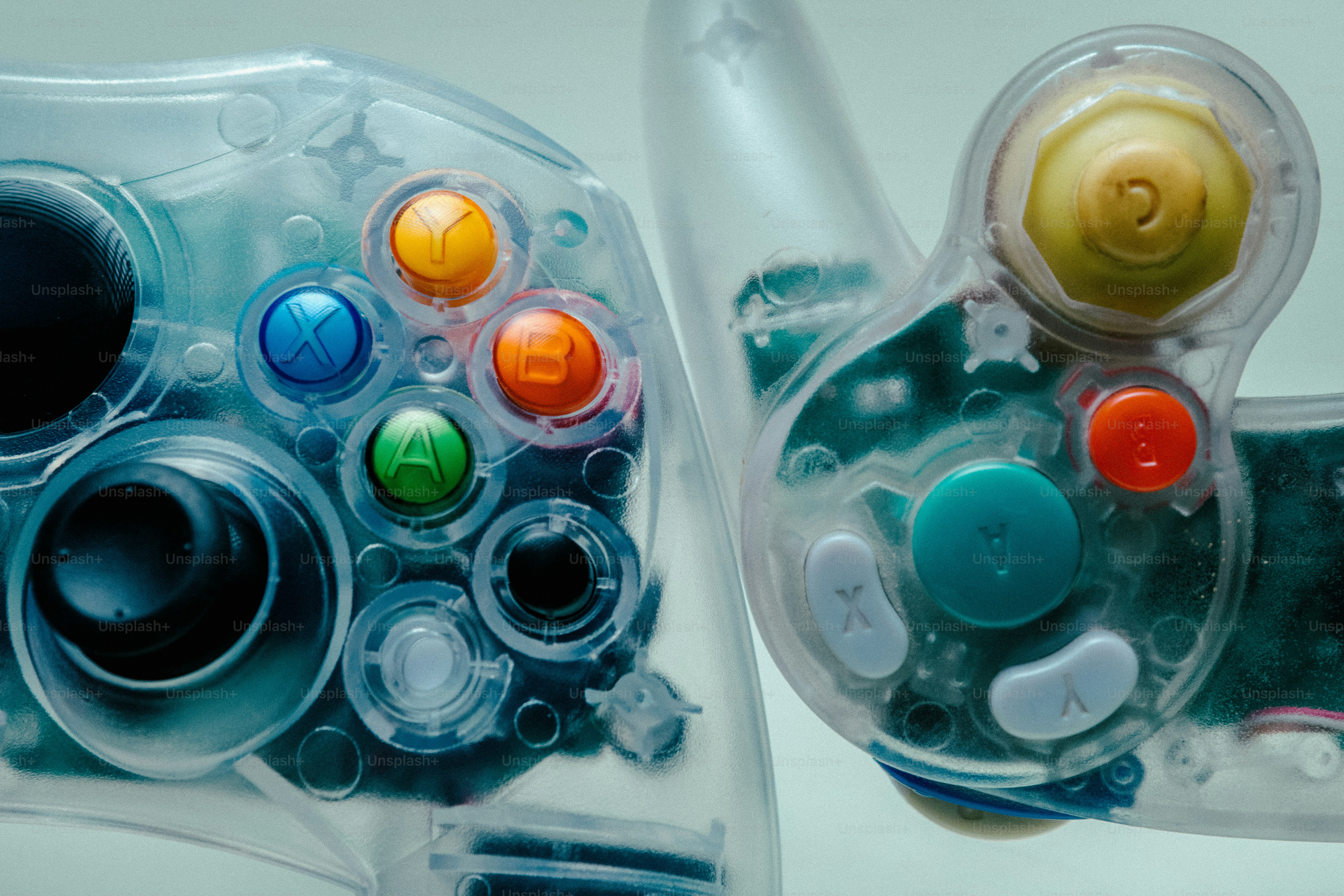 Two transparent video game controllers stacked vertically. photo ...
