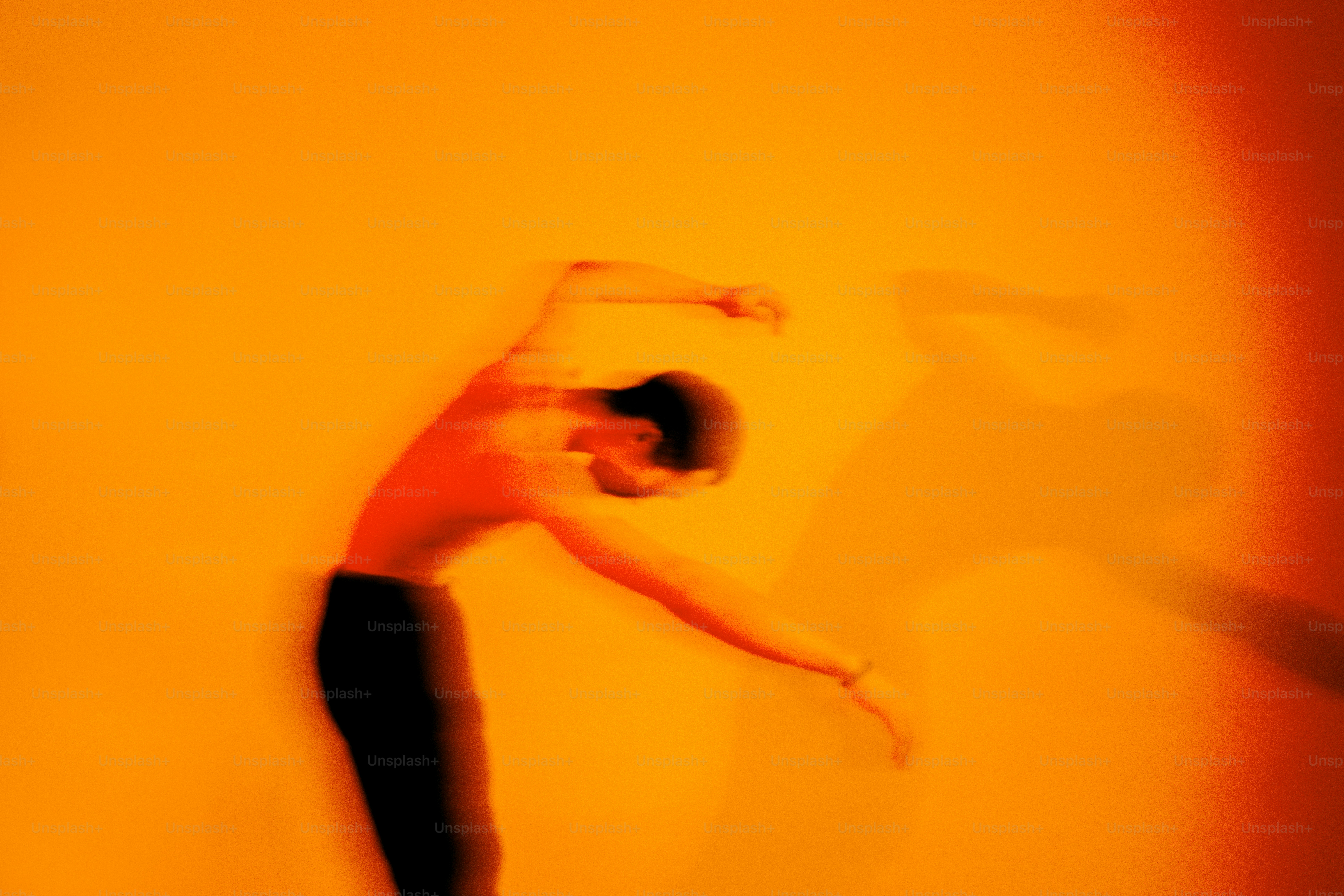 Blurred figure dancing against an orange background photo – Portrait ...