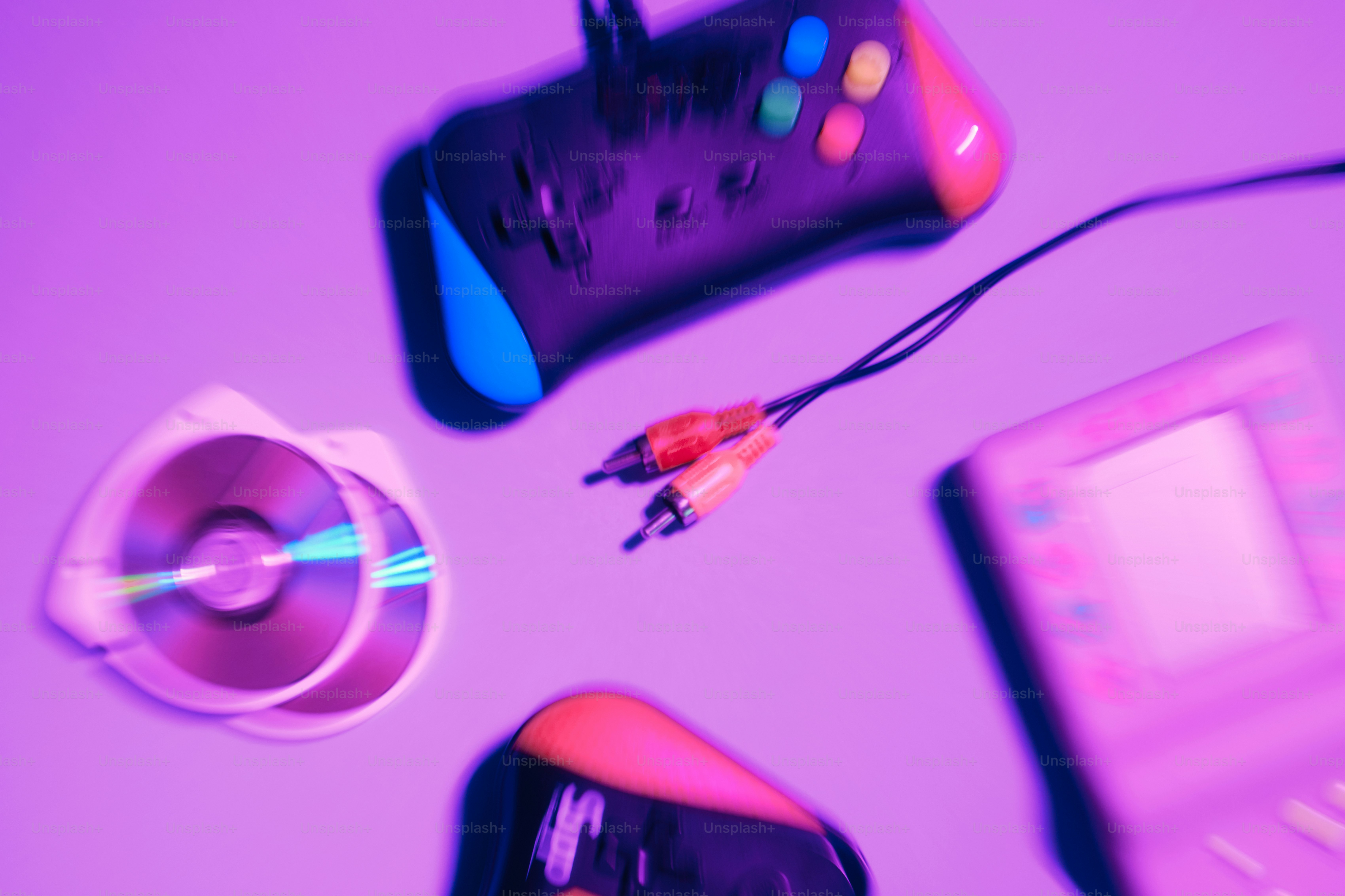 Retro gaming console, controllers, and disc on purple background photo ...