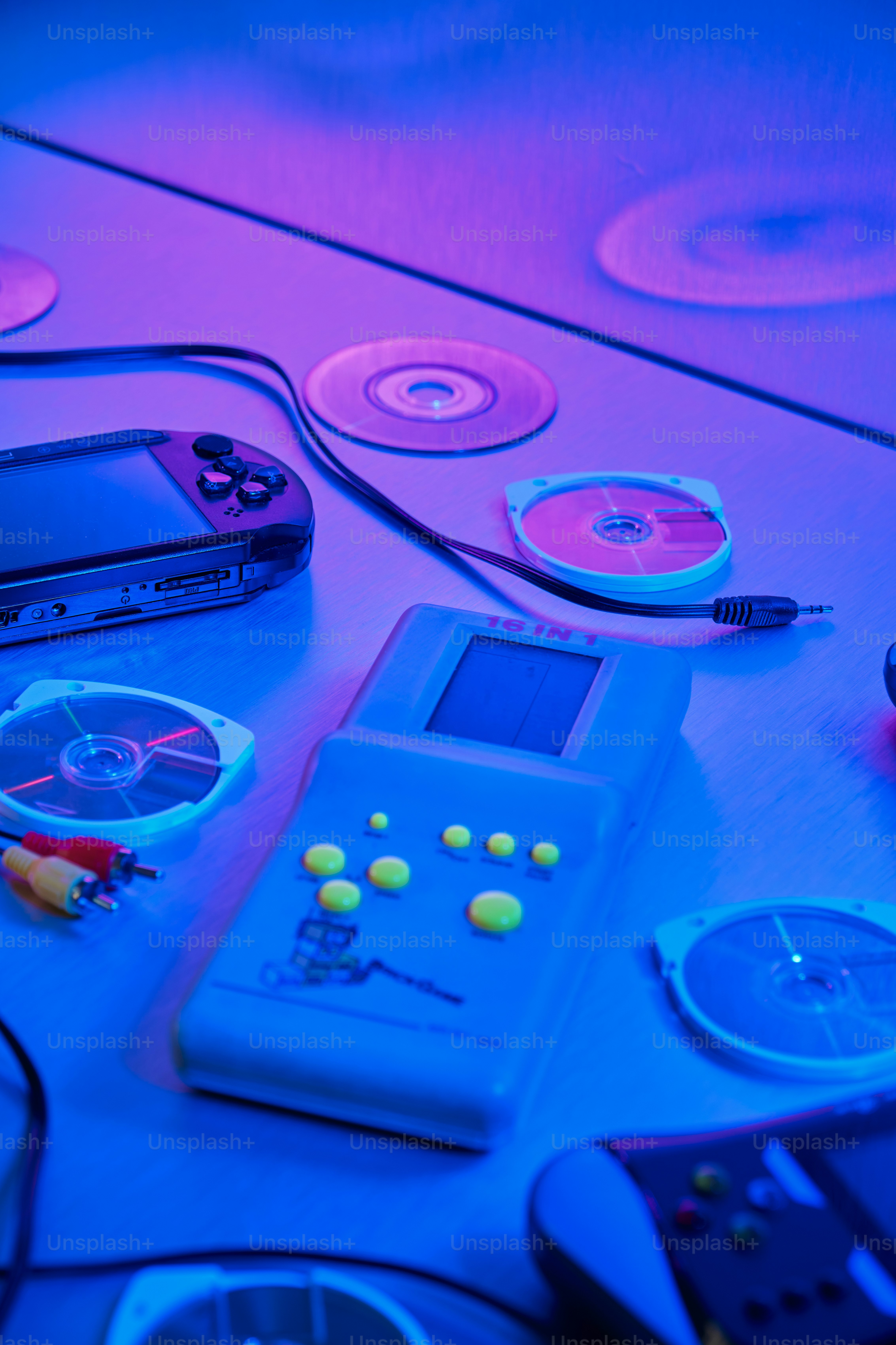 Retro gaming console, controllers, and disc on purple background photo ...