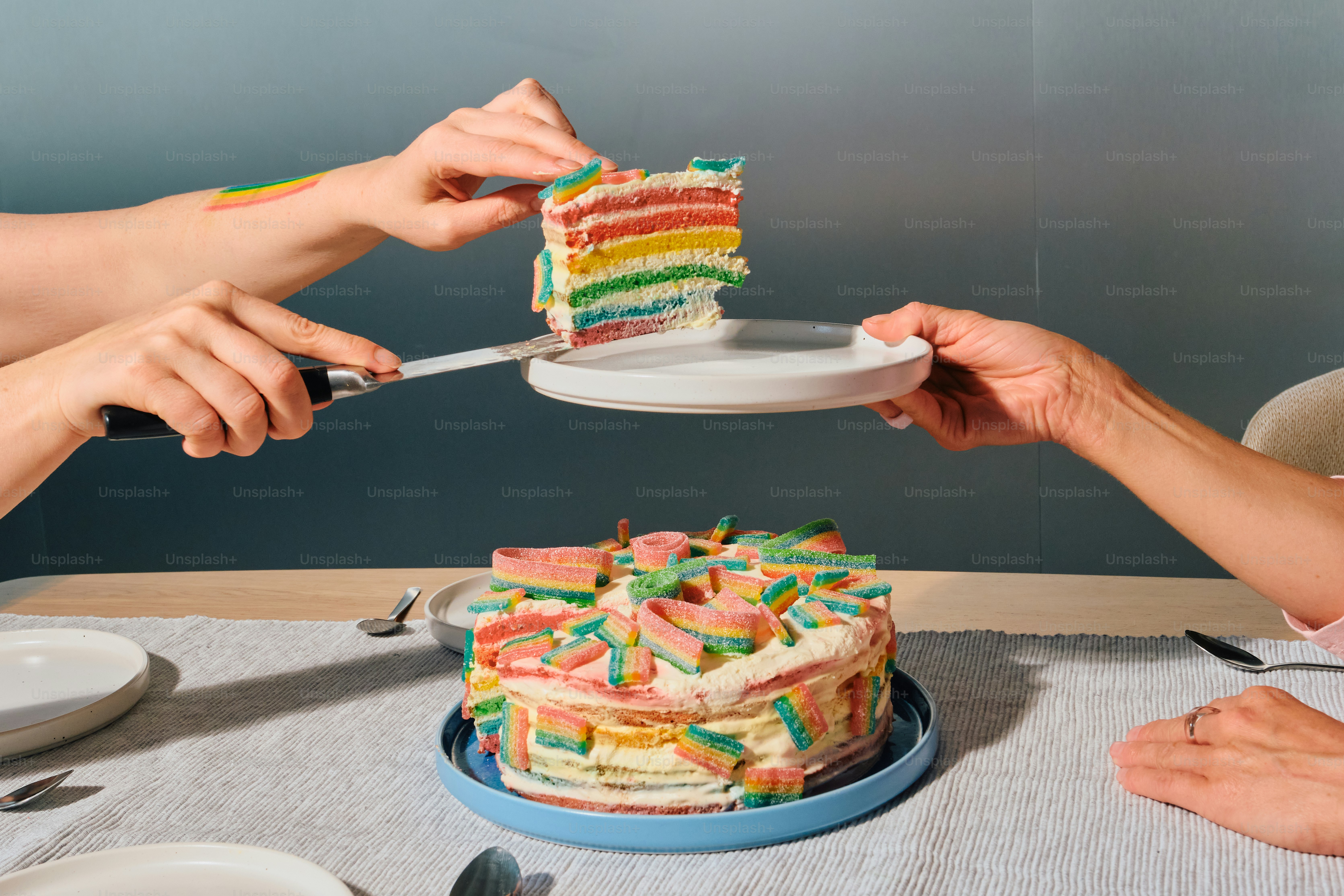 A rainbow cake with colorful layers and gummy decorations. photo ...