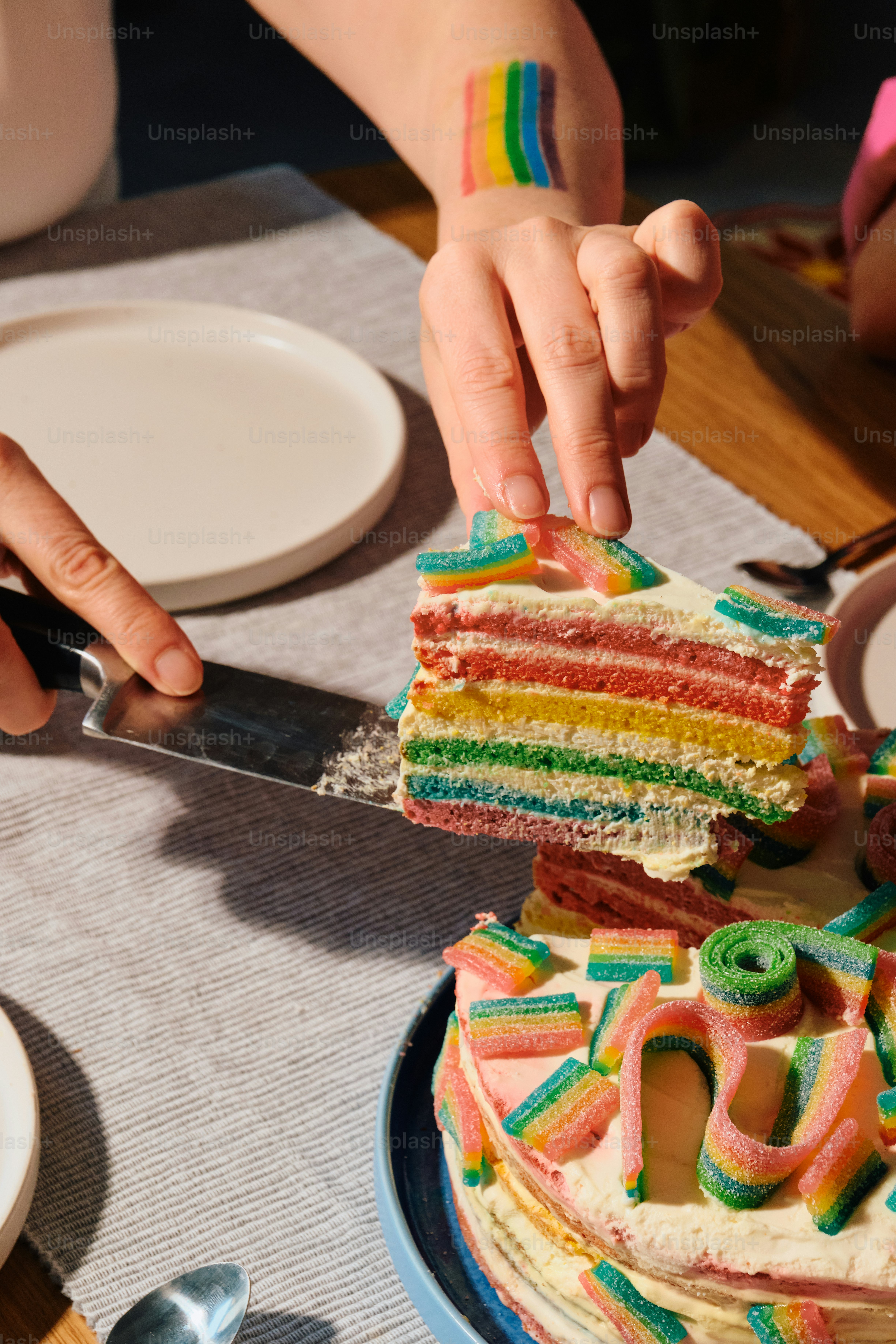 A rainbow cake with colorful layers and gummy decorations. photo ...