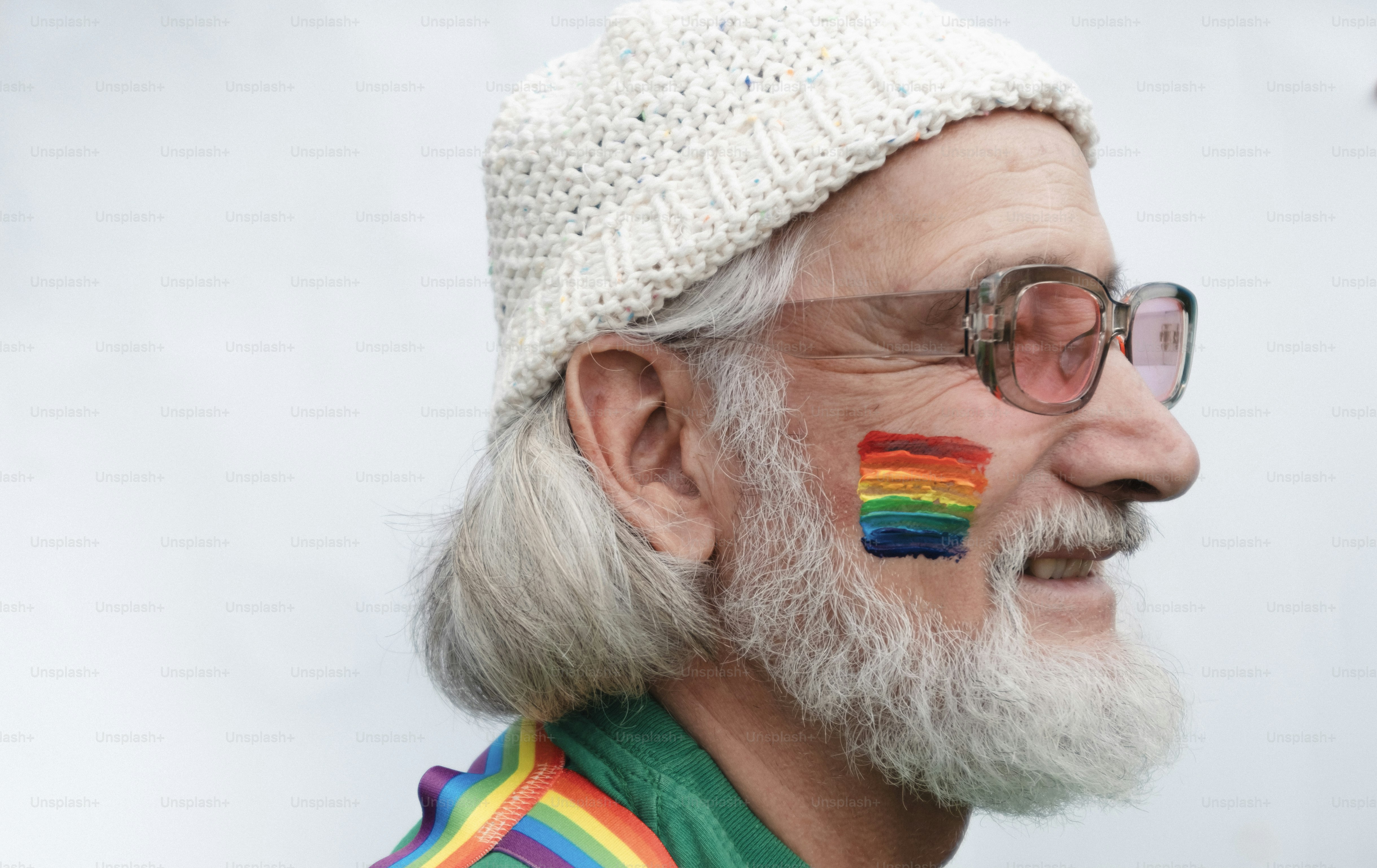 Elderly man with rainbow flag face paint smiles joyfully photo ...