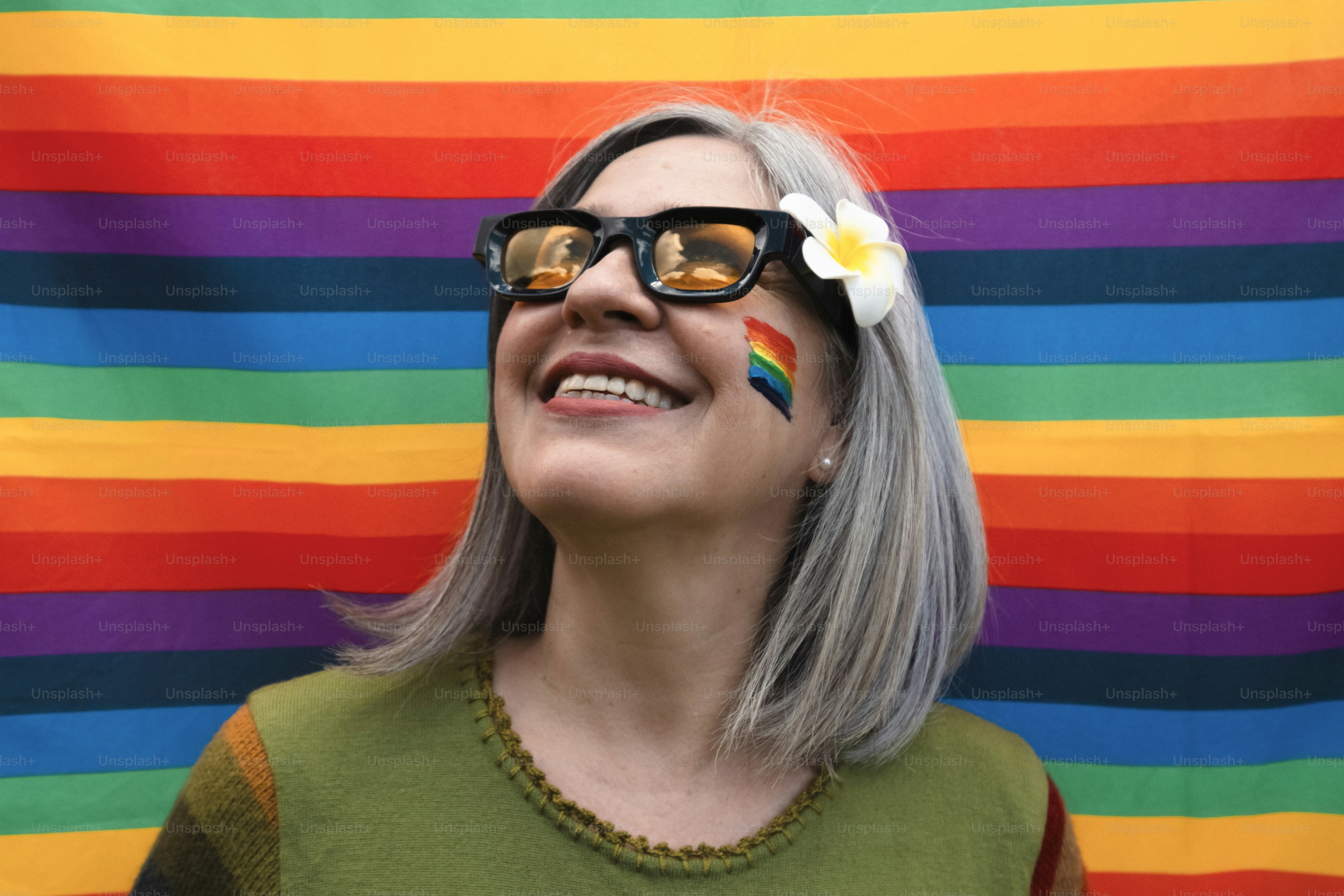 Elderly man with rainbow flag face paint smiles joyfully photo ...