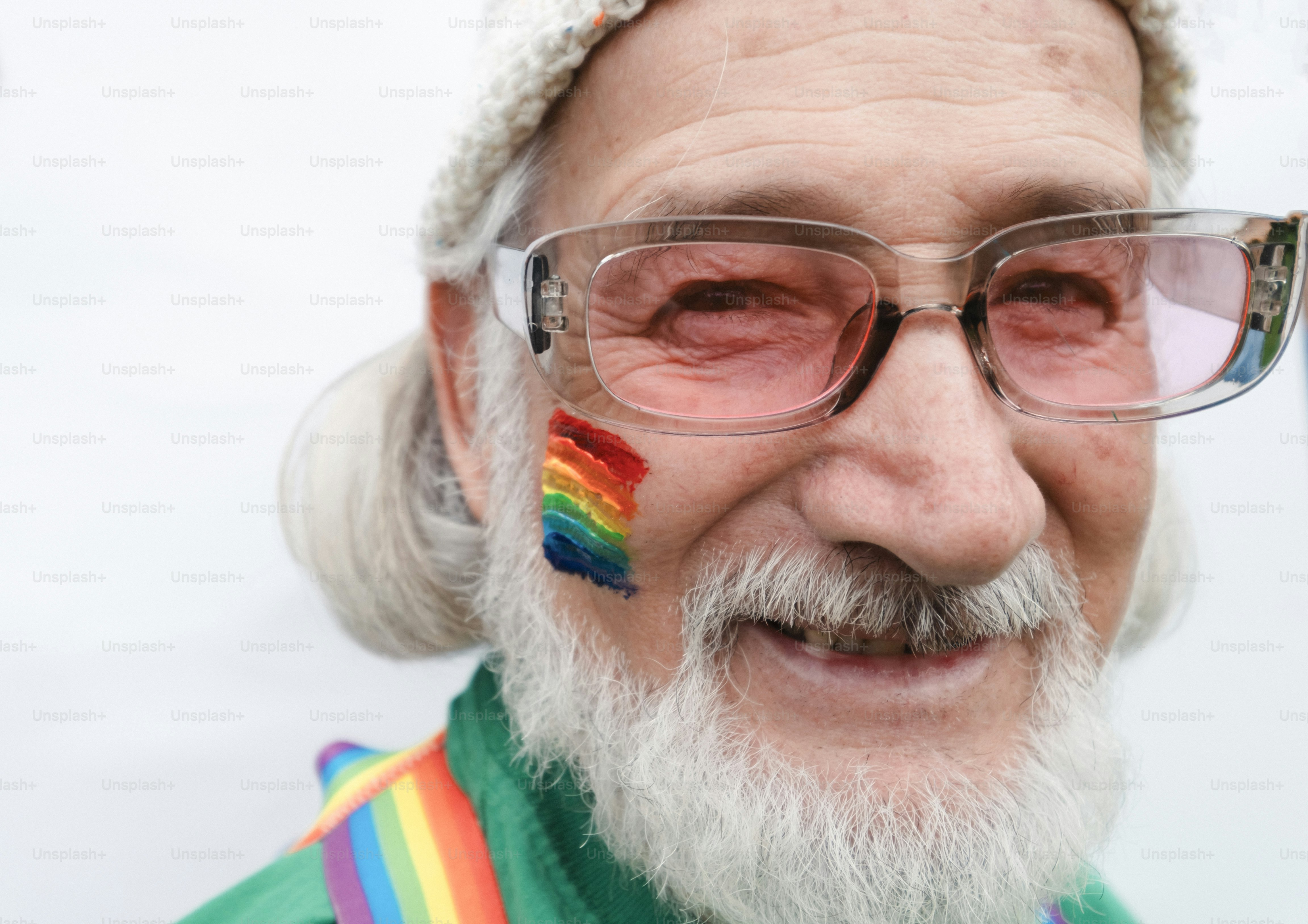 Elderly man with rainbow flag face paint smiles joyfully photo ...