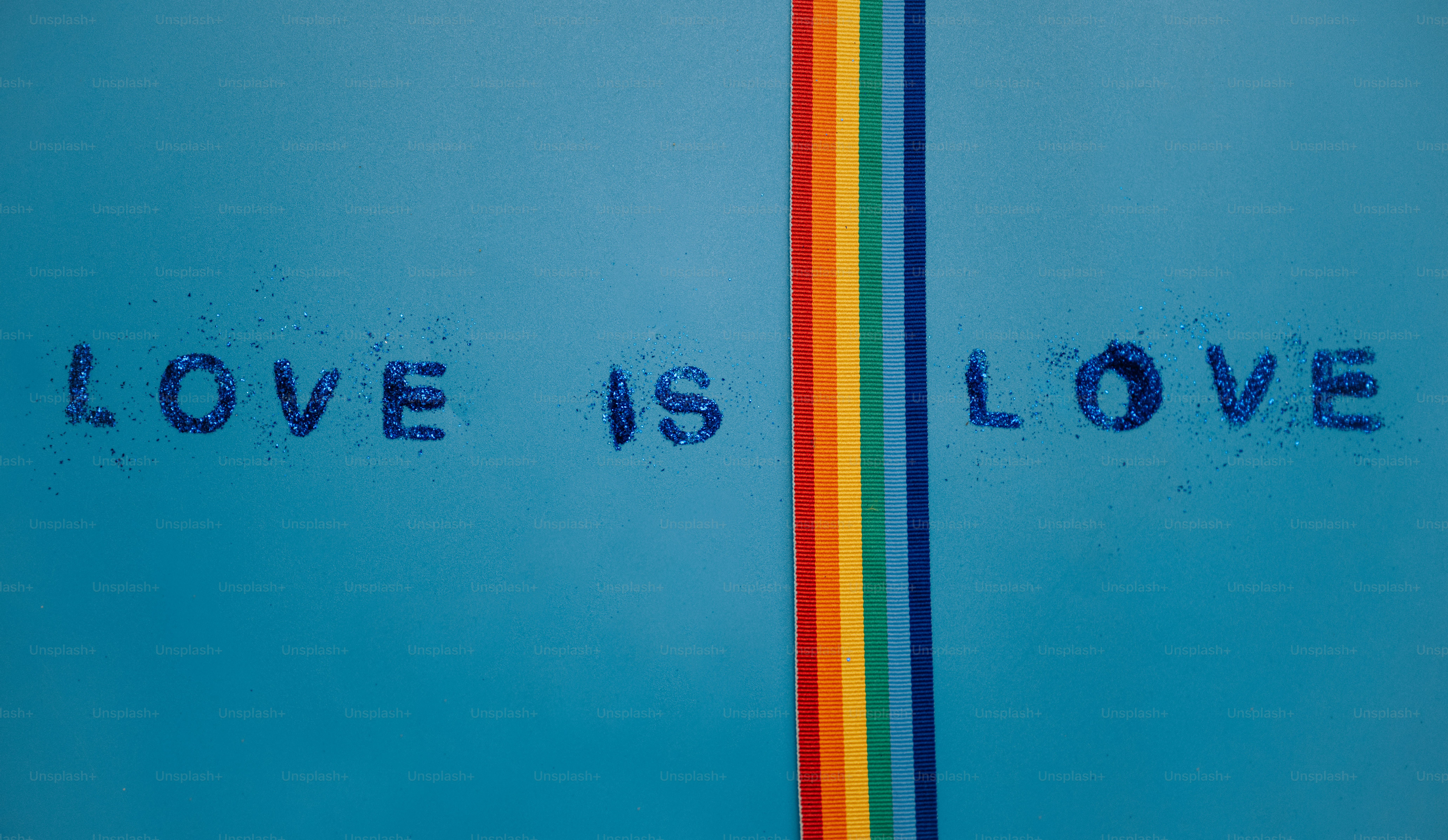 Rainbow stripes divide "love is love" text on blue. photo – Blue ...
