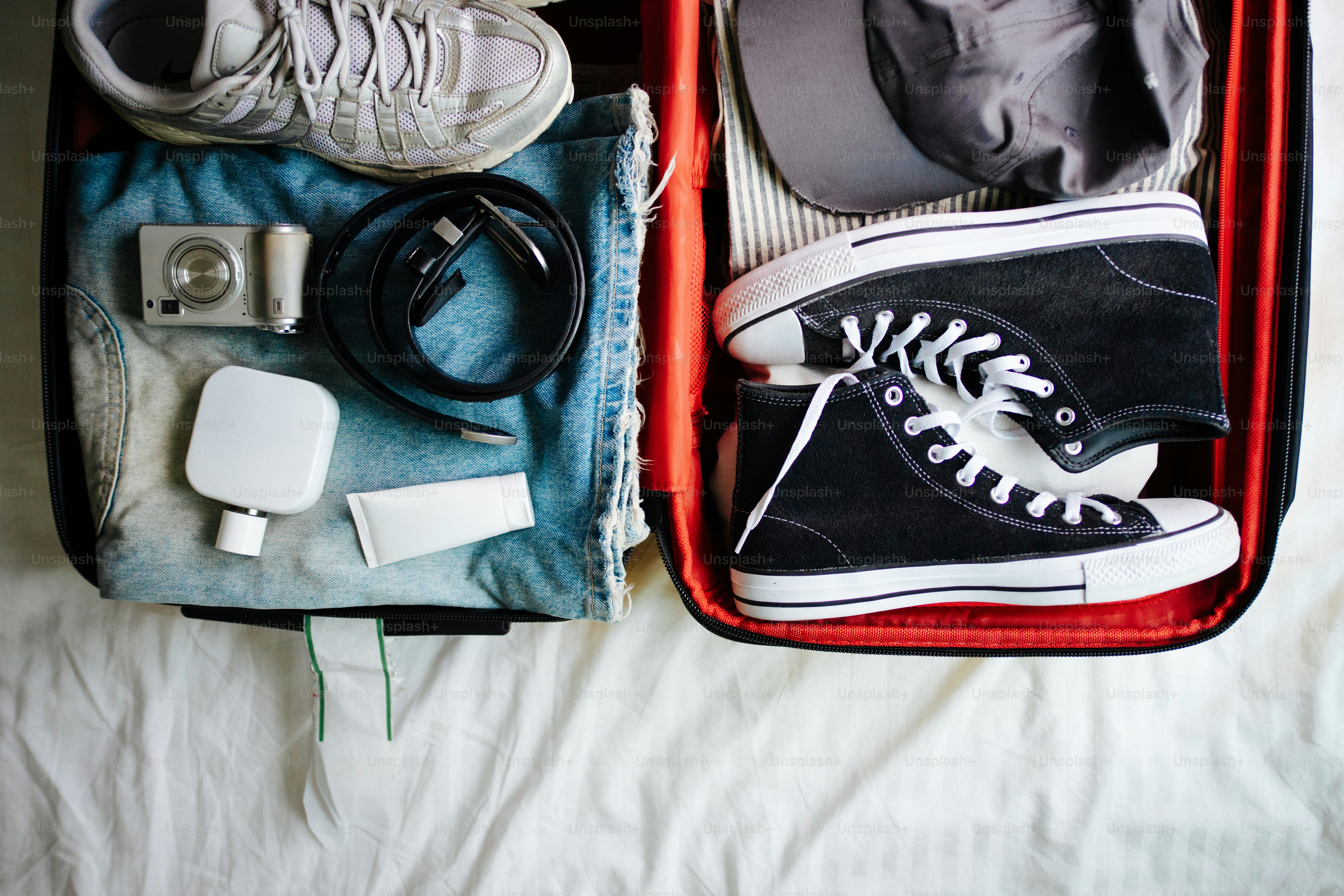 Yellow suitcase overflowing with clothes and shoes on green sofa. photo ...