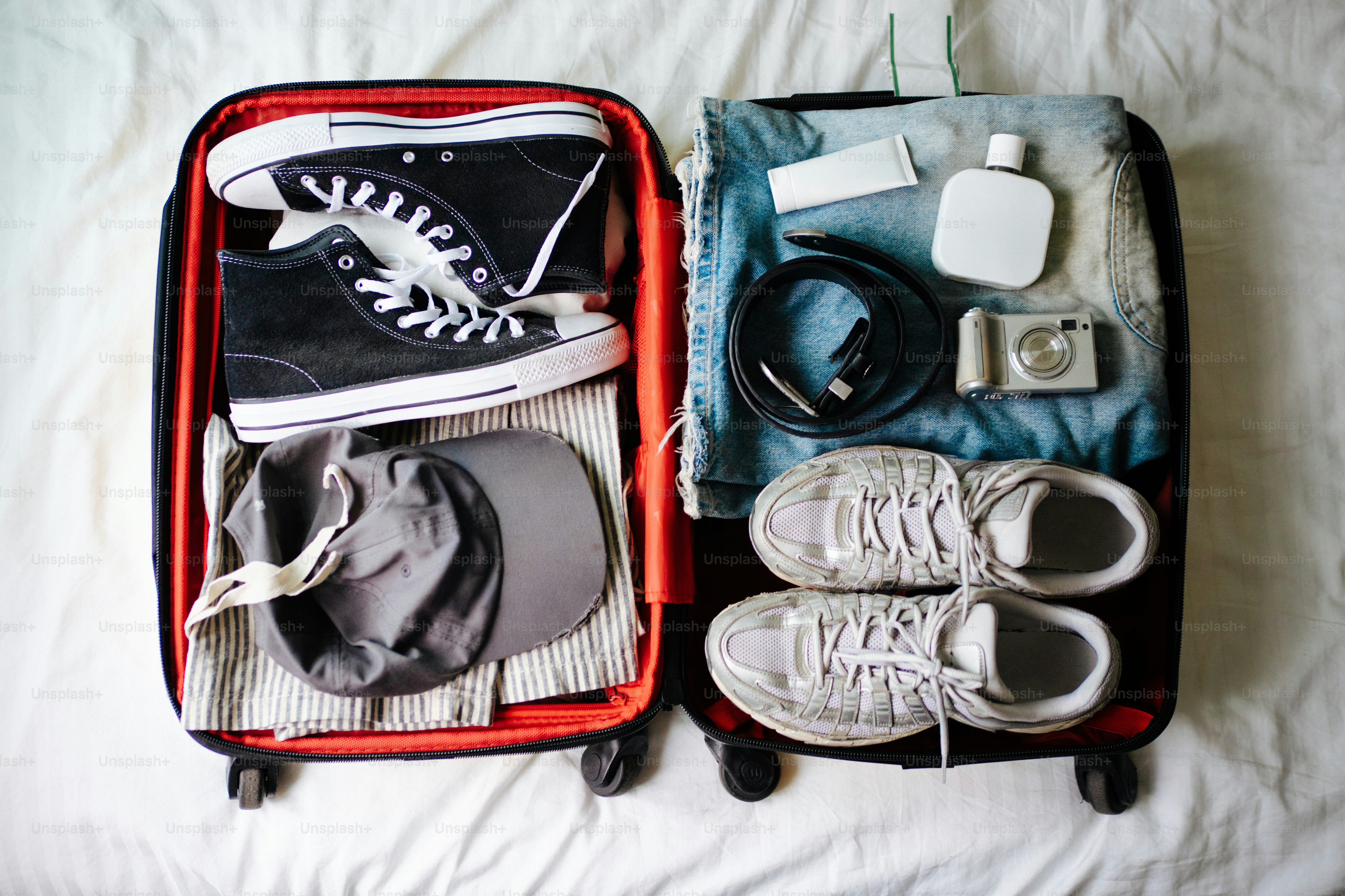 Yellow suitcase overflowing with clothes and shoes on green sofa. photo ...