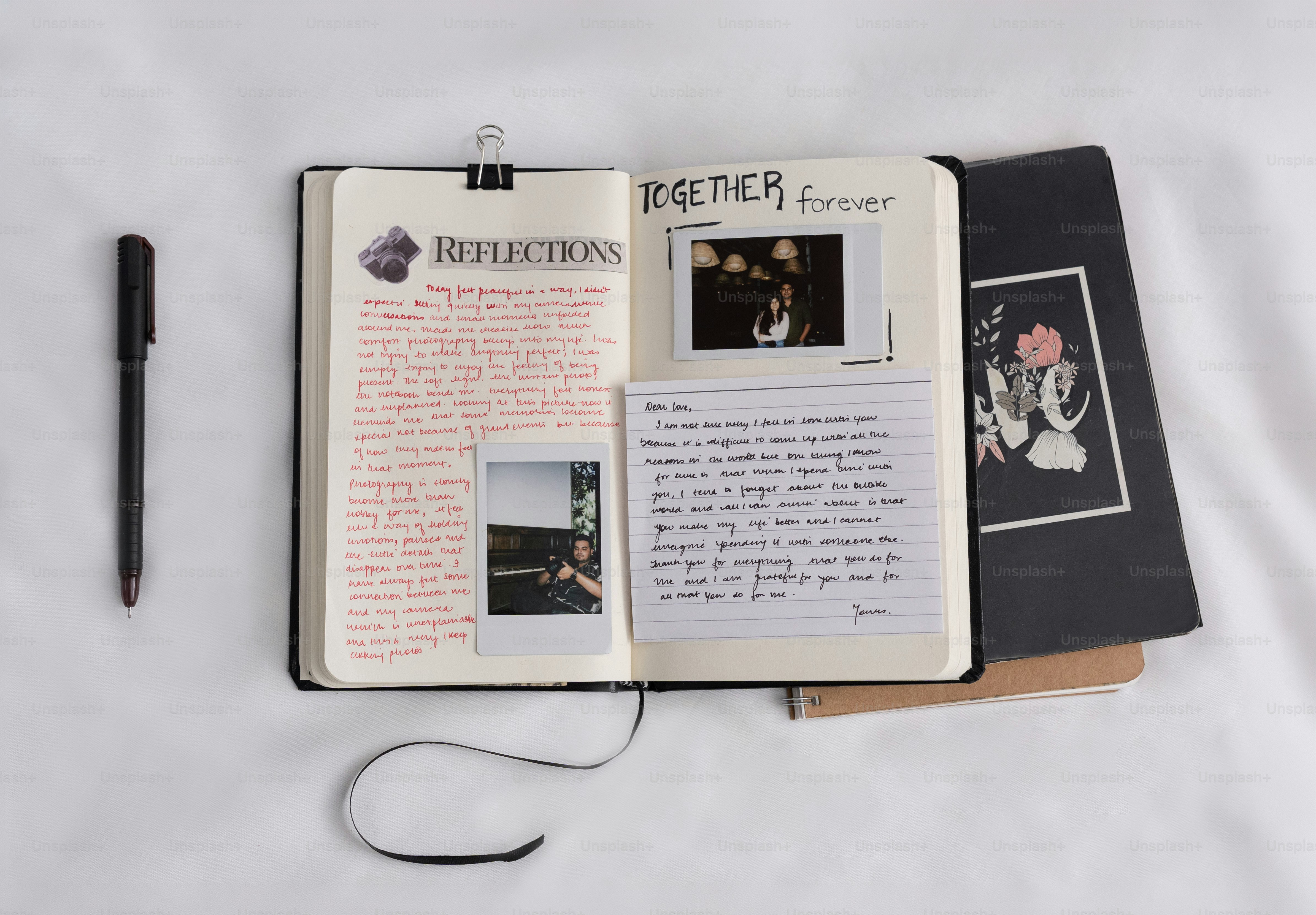 Open journal displaying handwritten notes, photos, and pen. photo ...