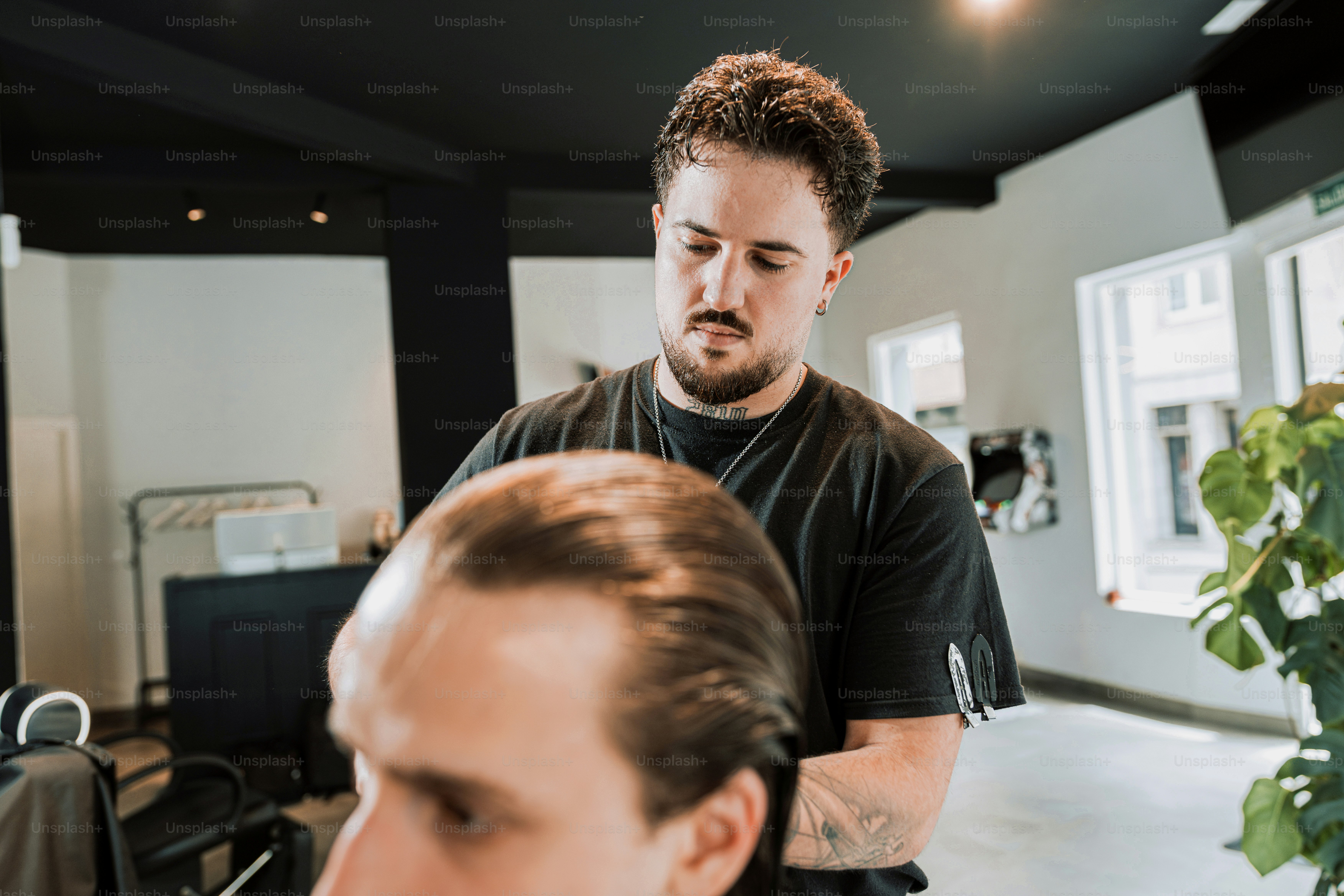 Professional barber cutting a man's hair in a barbershop. photo ...