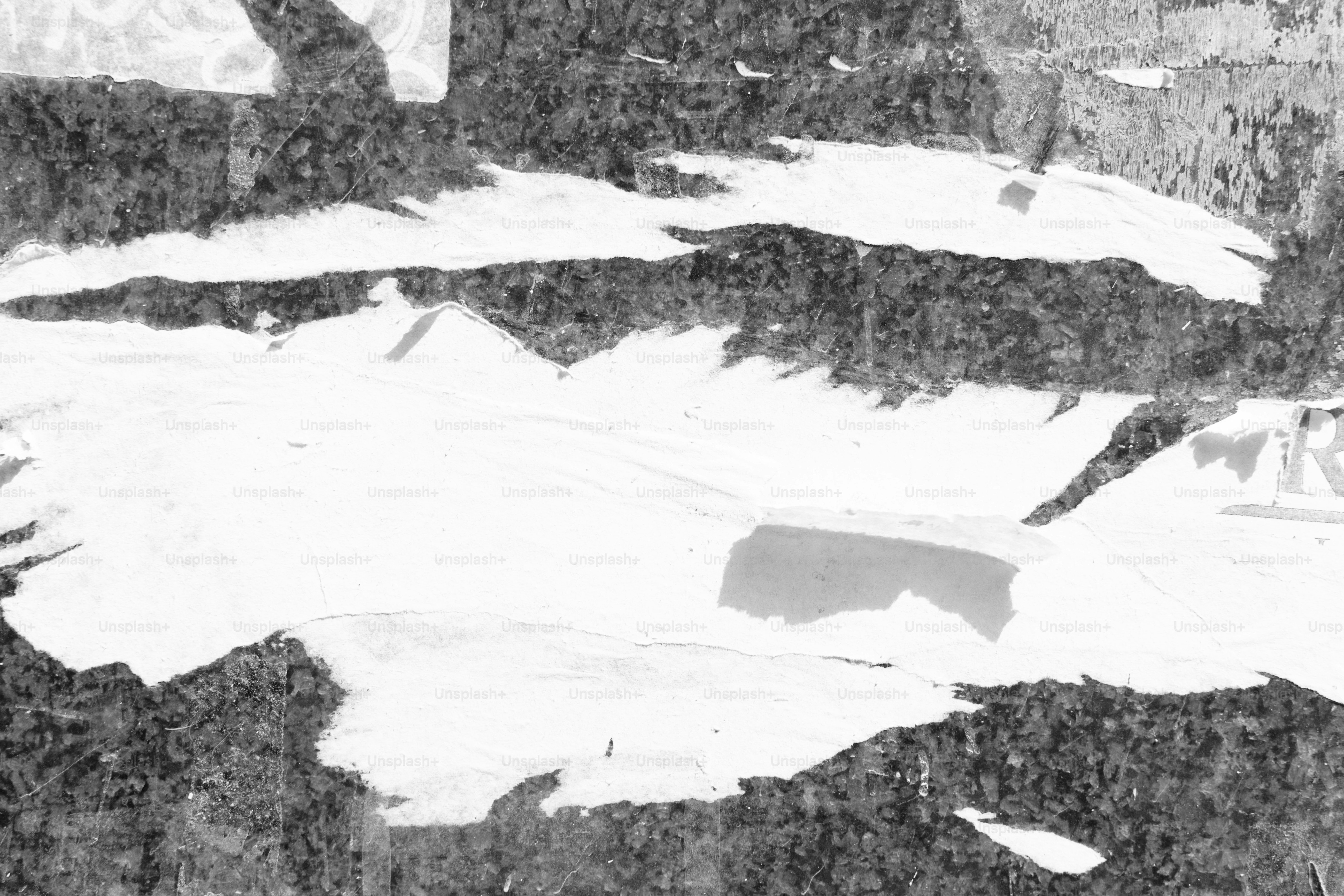 Torn white paper scraps on a dark, textured wall. photo – Wallpaper ...