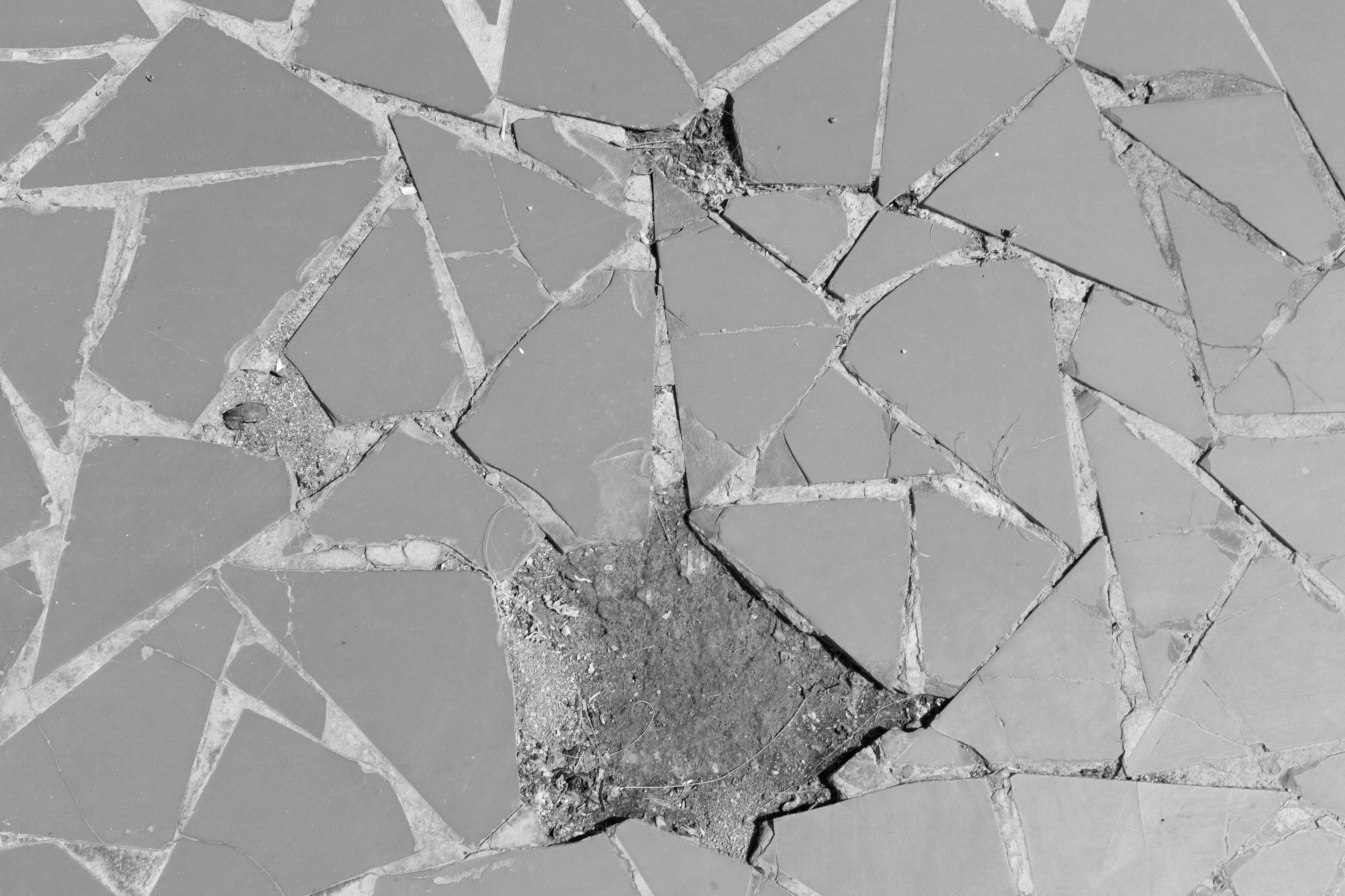 Broken gray tiles with missing pieces and exposed concrete. photo ...